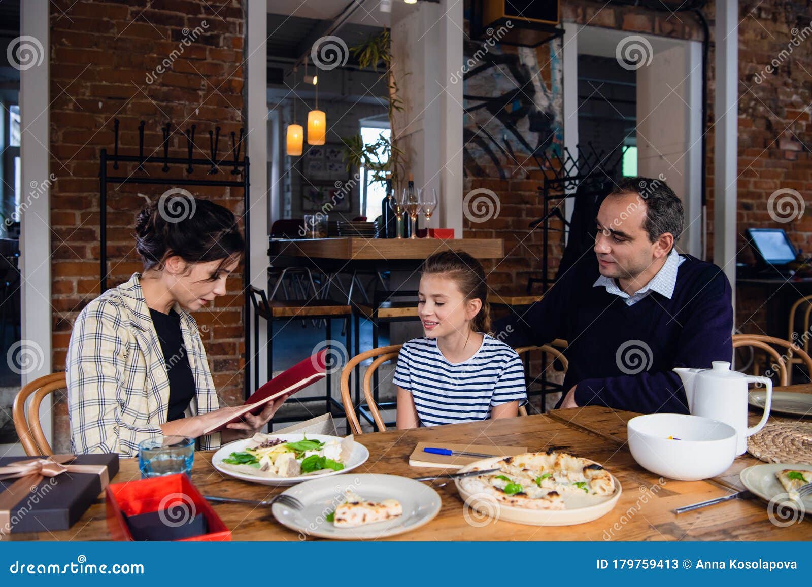 A Family Reading a Book after a Nice Meal Stock Image - Image of mother ...
