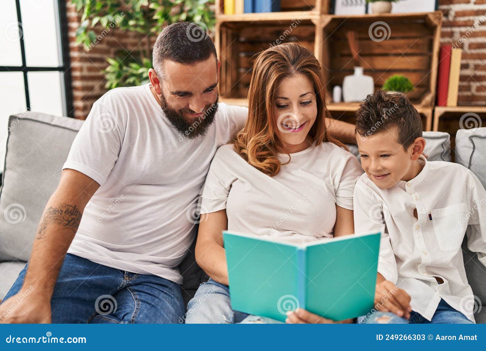 Family Reading Book Sitting on Sofa at Home Stock Image - Image of ...