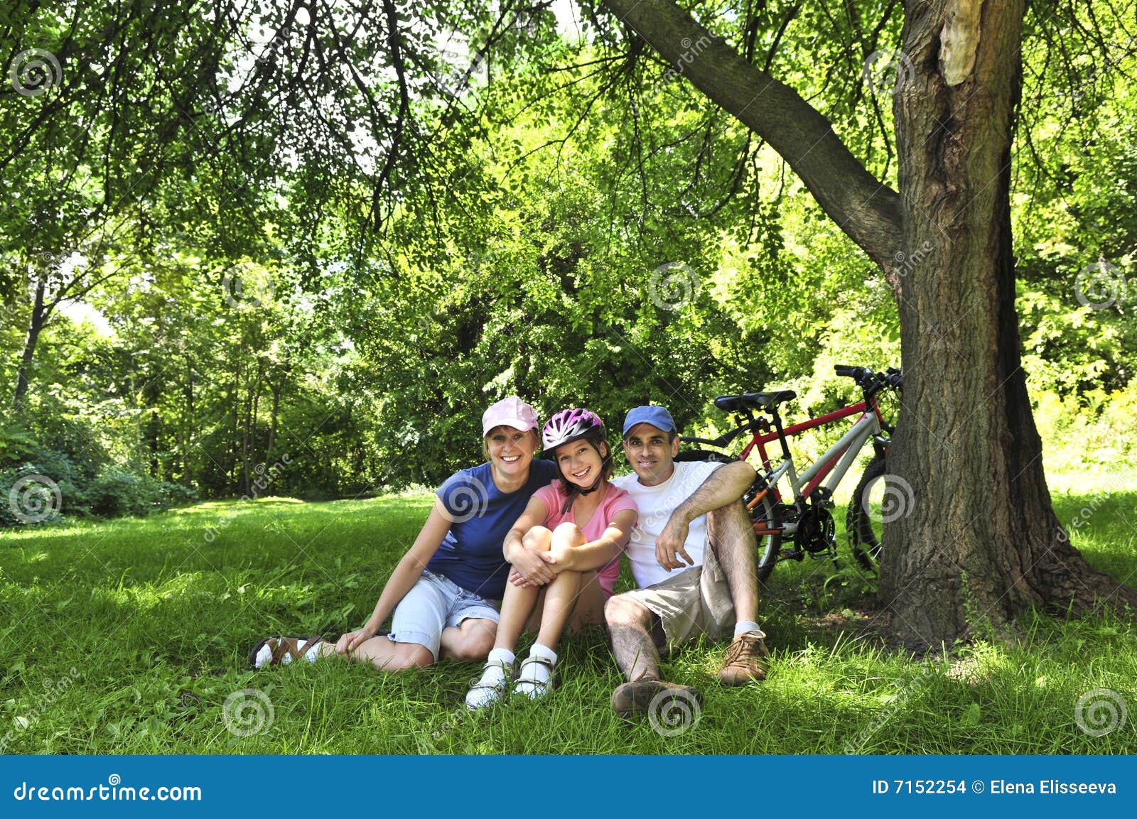 Family resting in a park stock photo. Image of bicycle - 7152254