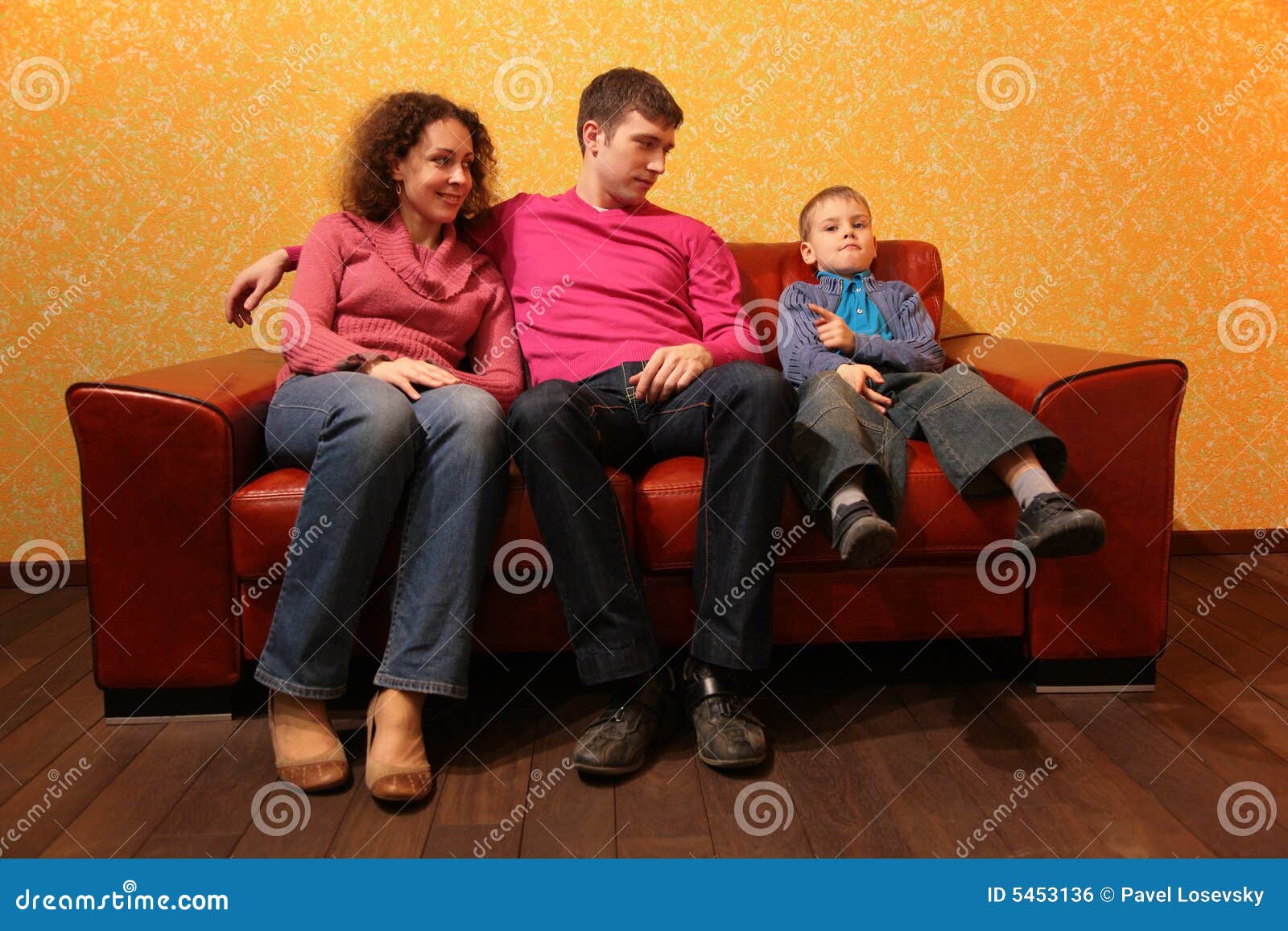 Family Seating on Red Leather Sofa Stock Photo - Image of adult, mother ...