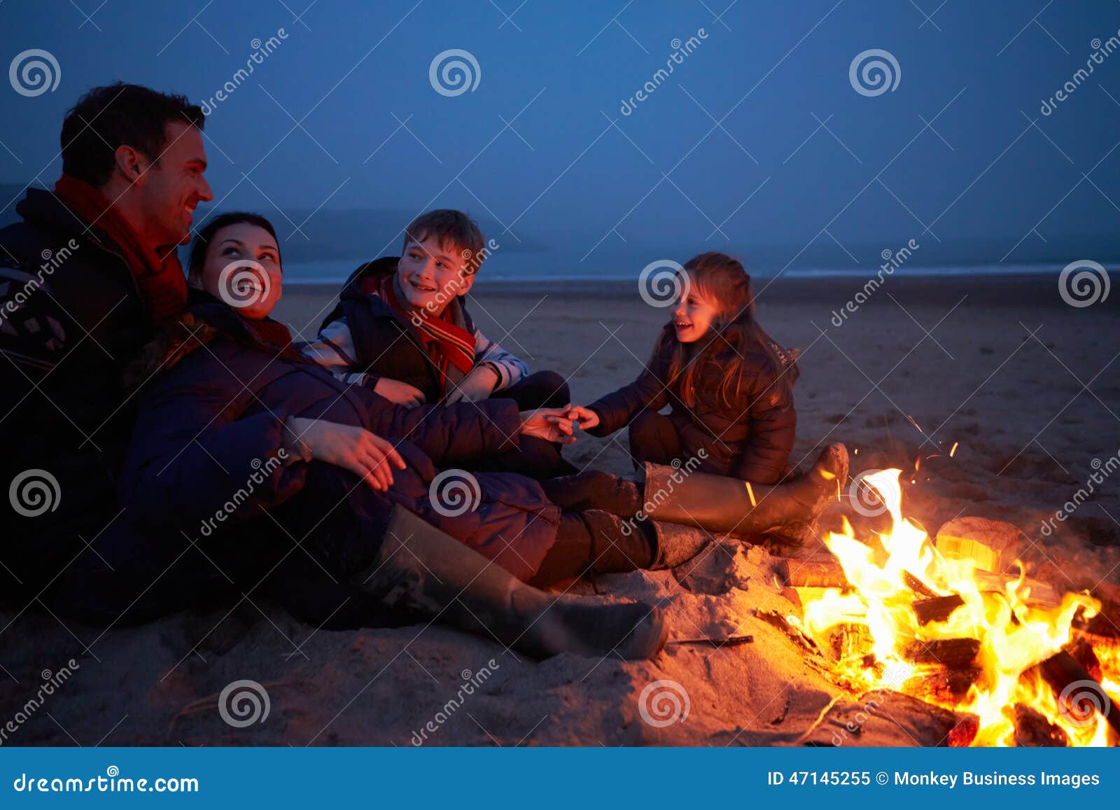 Family Sitting by Fire on Winter Beach Stock Image - Image of walk ...