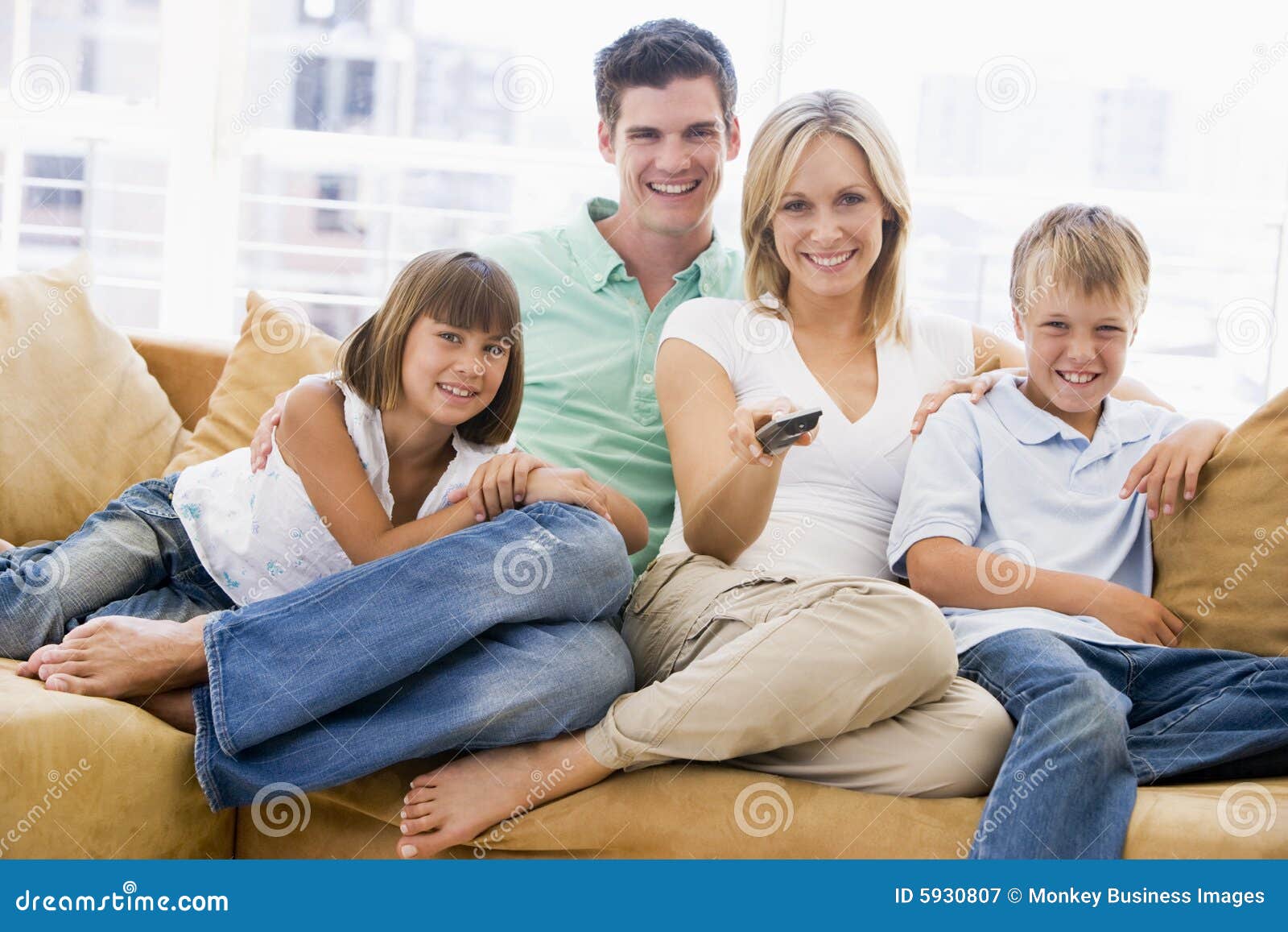 Family Sitting in Living Room with Remote Control Stock Image - Image ...