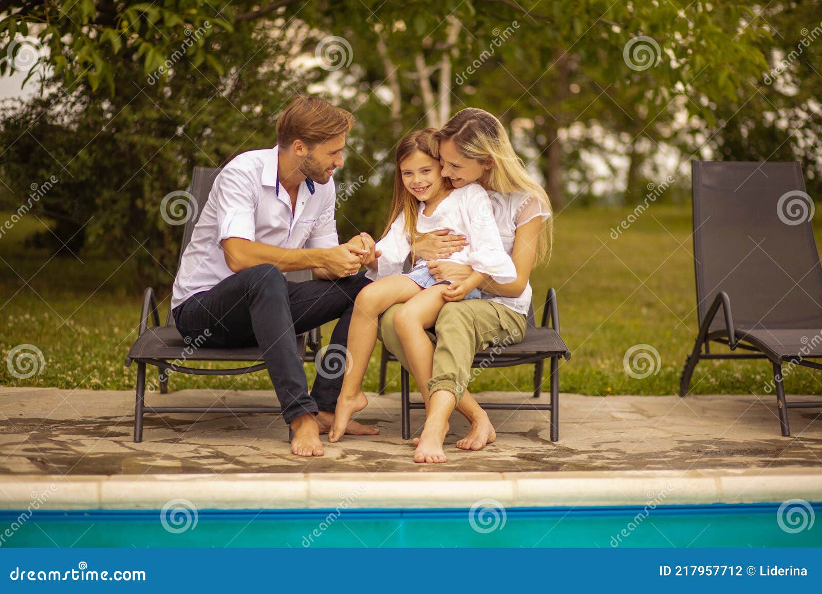 Family sitting by the pool stock photo. Image of ethnicity - 217957712