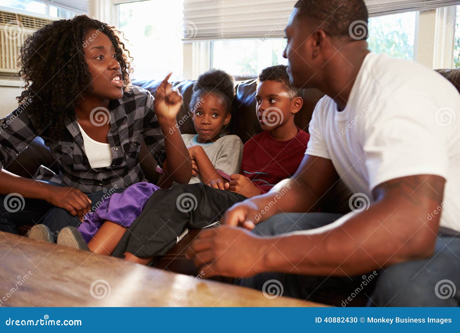 Family Sitting On Sofa With Parents Arguing Stock Photo - Image: 40882430