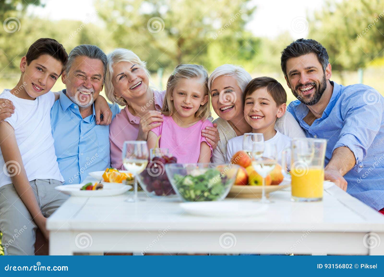 Family Sitting at Table Outdoors, Smiling Stock Photo - Image of lunch ...
