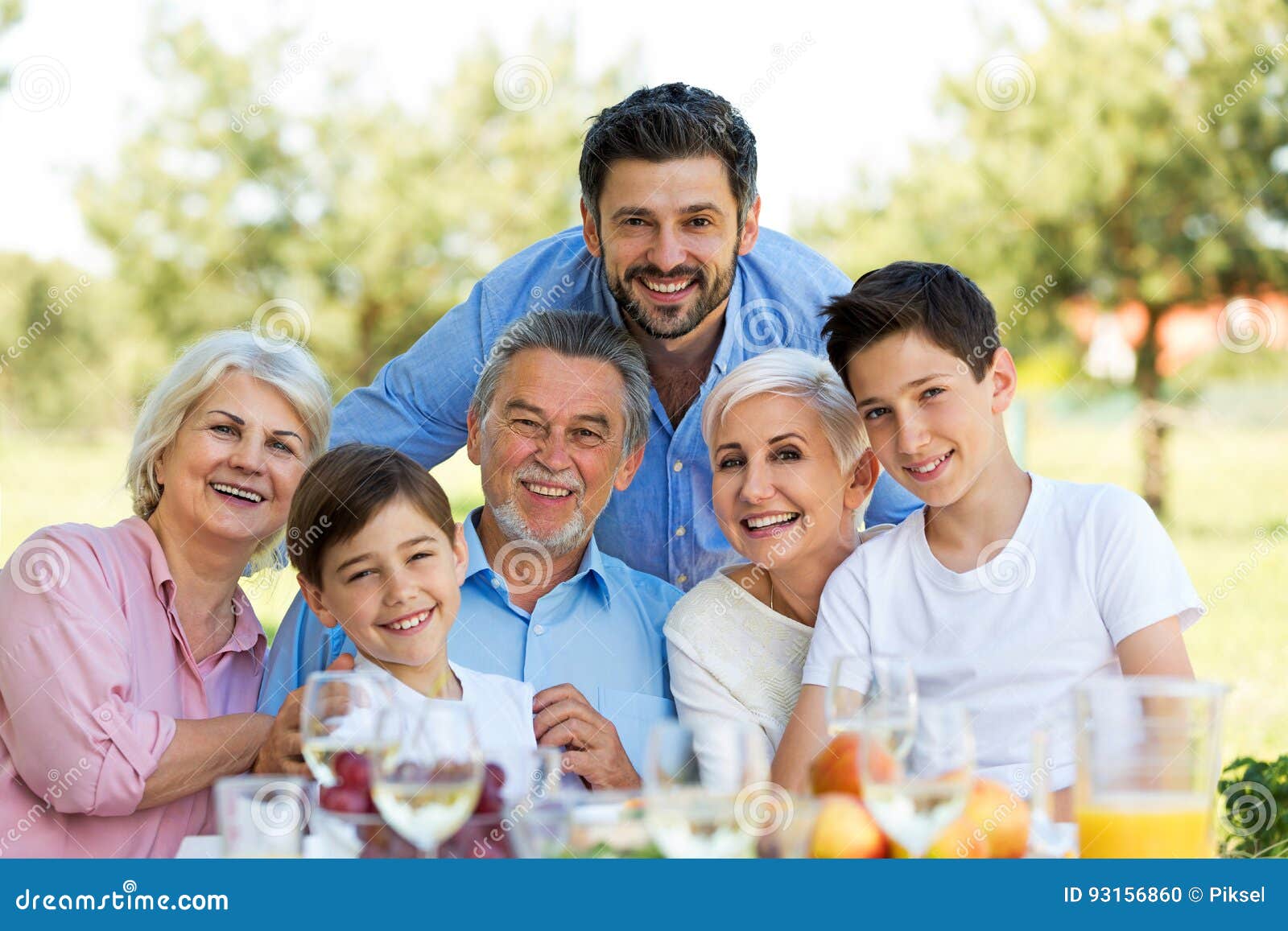 Family Sitting at Table Outdoors, Smiling Stock Photo - Image of female ...