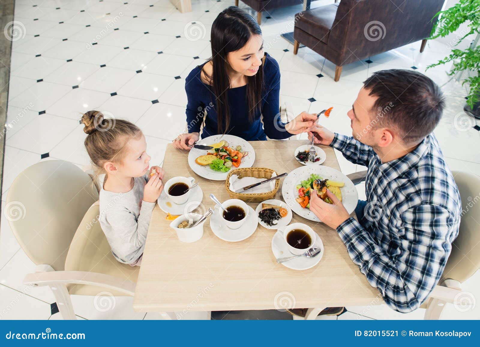Family Sitting Together at Table in a Restaurant Stock Image - Image of ...