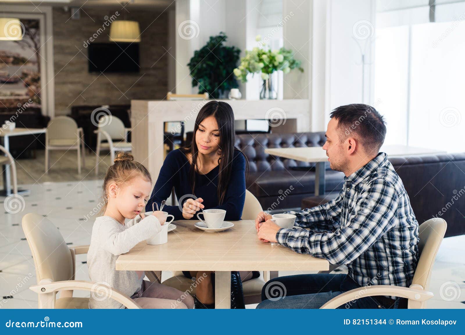 Family Sitting Together at Table in a Restaurant Stock Photo - Image of ...