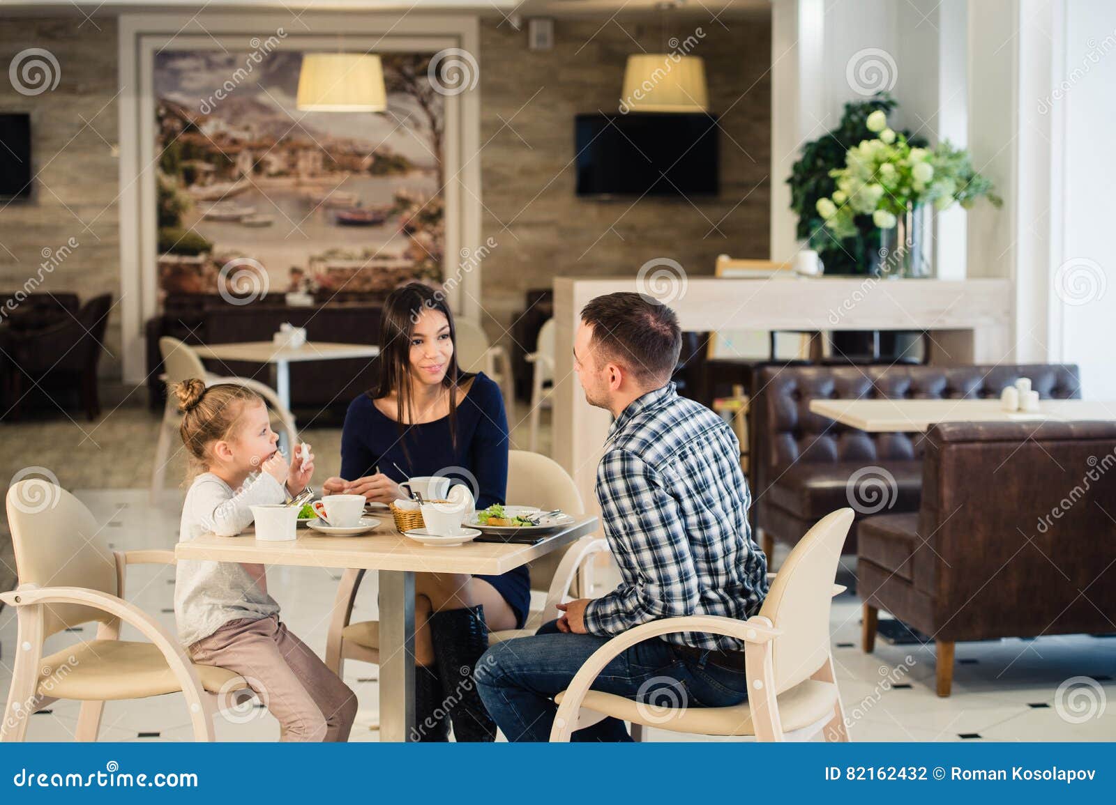 Family Sitting Together at Table in a Restaurant Stock Photo - Image of ...
