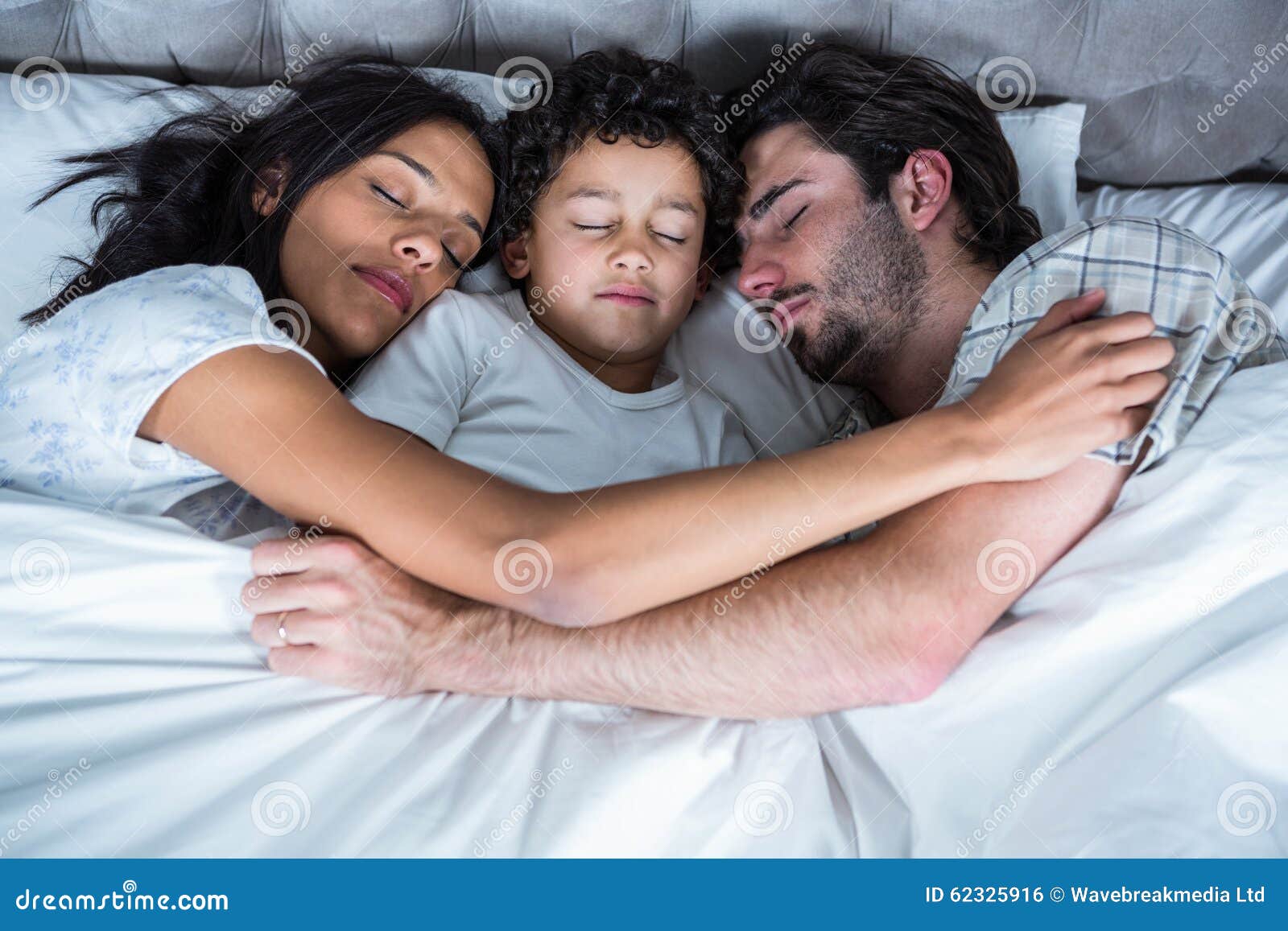 Family sleeping together stock photo. Image of cushions - 62325916