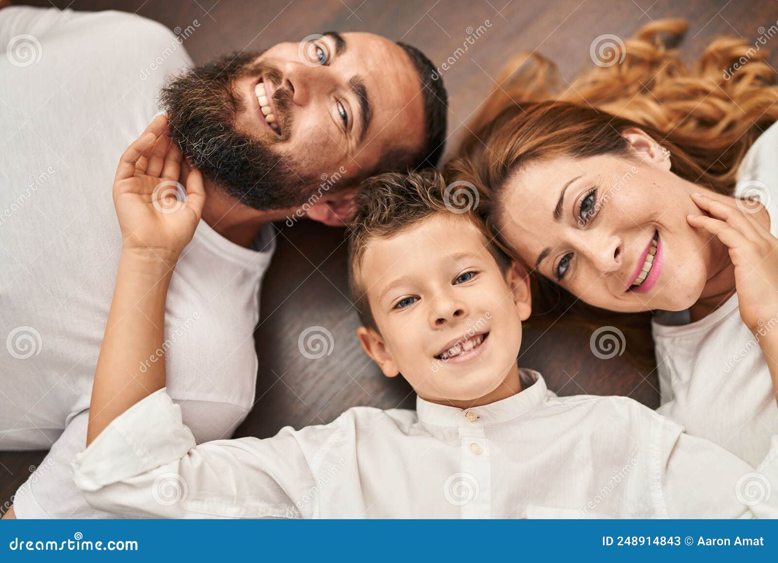 Family Smiling Confident Lying on Floor at Home Stock Image - Image of ...