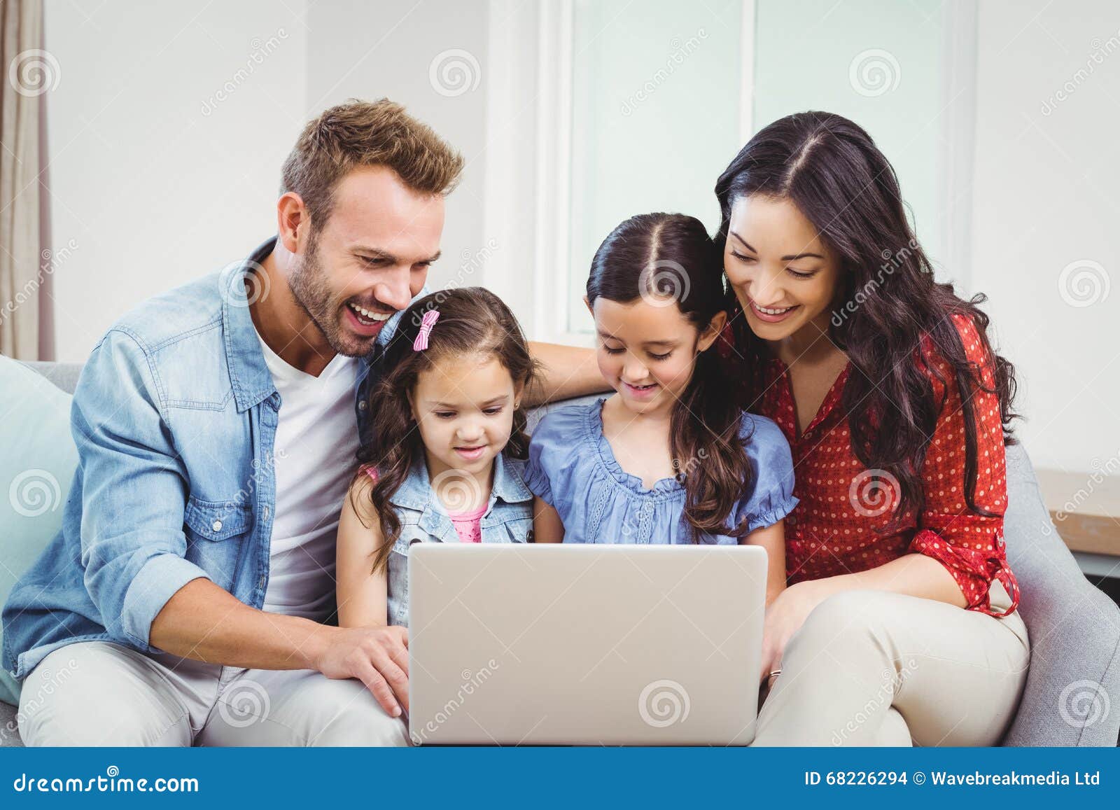 Family Smiling and Looking in Laptop on Sofa Stock Photo - Image of ...