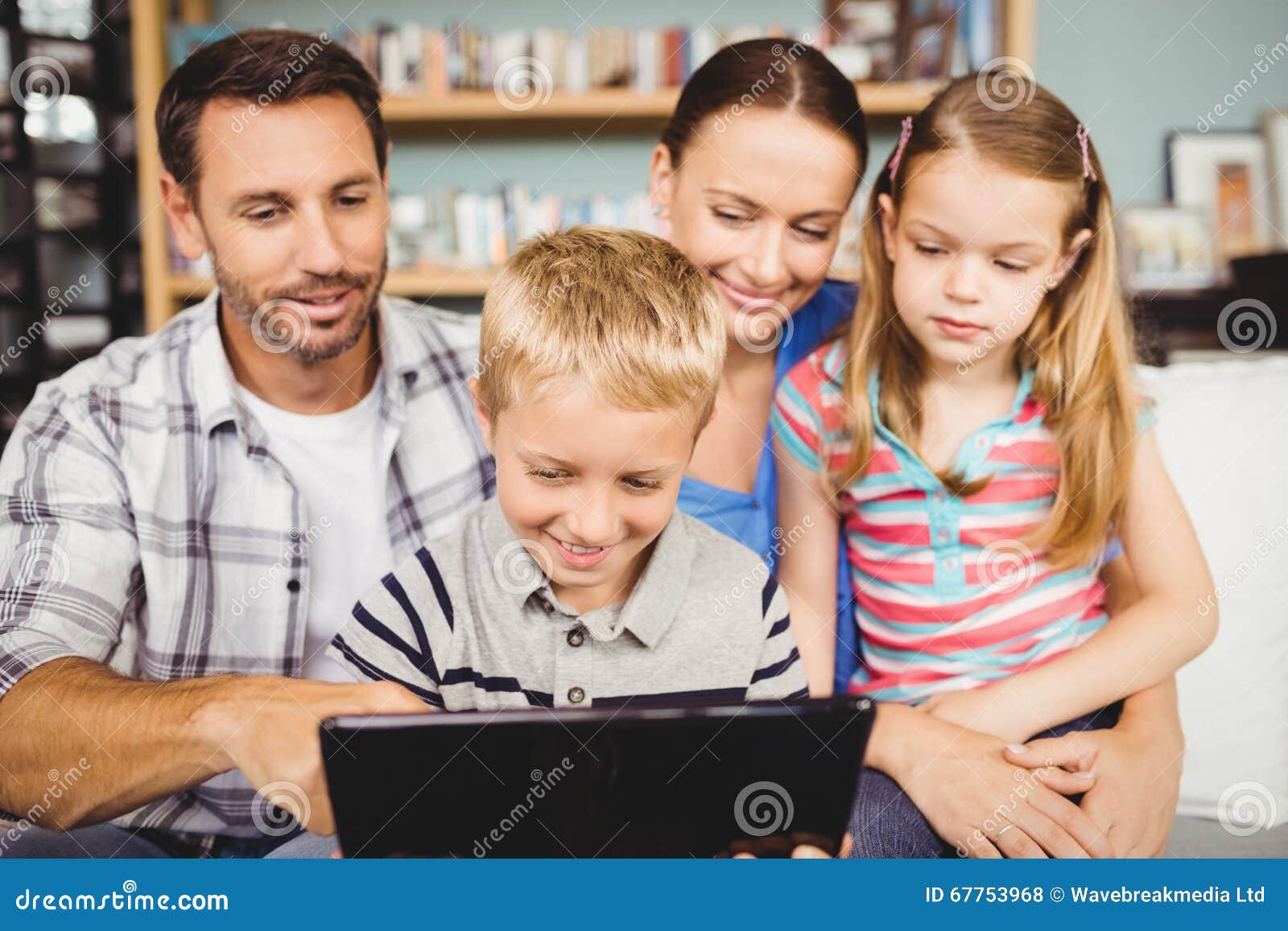 Family Smiling while Using Technologies on Sofa at Home Stock Photo ...