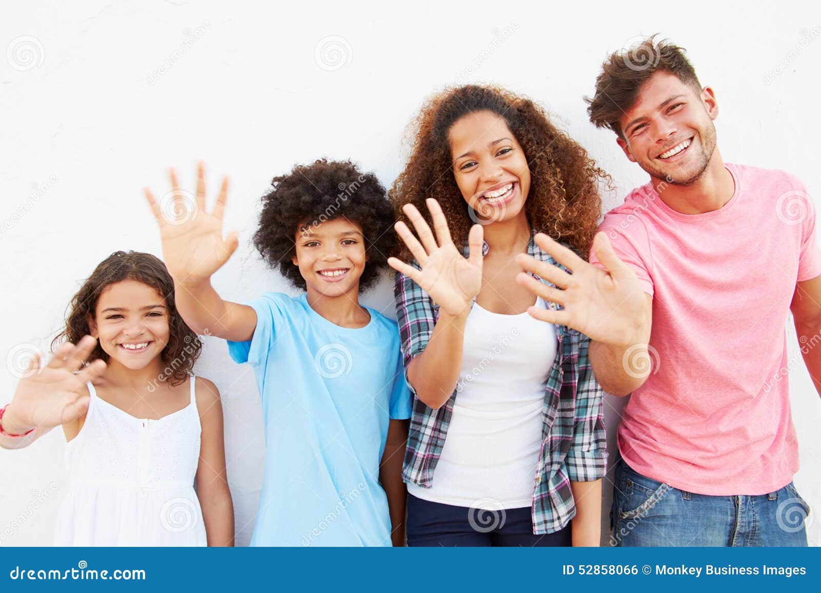 Family Standing Outdoors Against White Wall and Waving Stock Photo ...
