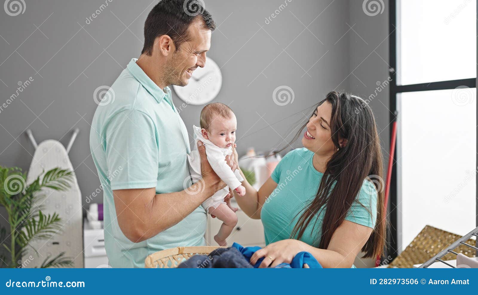 Family of Three Hanging Clothes on Clothesline at Laundry Room Stock ...
