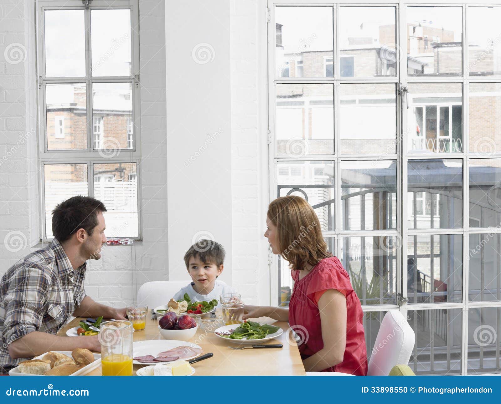 Family of Three Having Meal at Dining Table Stock Photo - Image of ...
