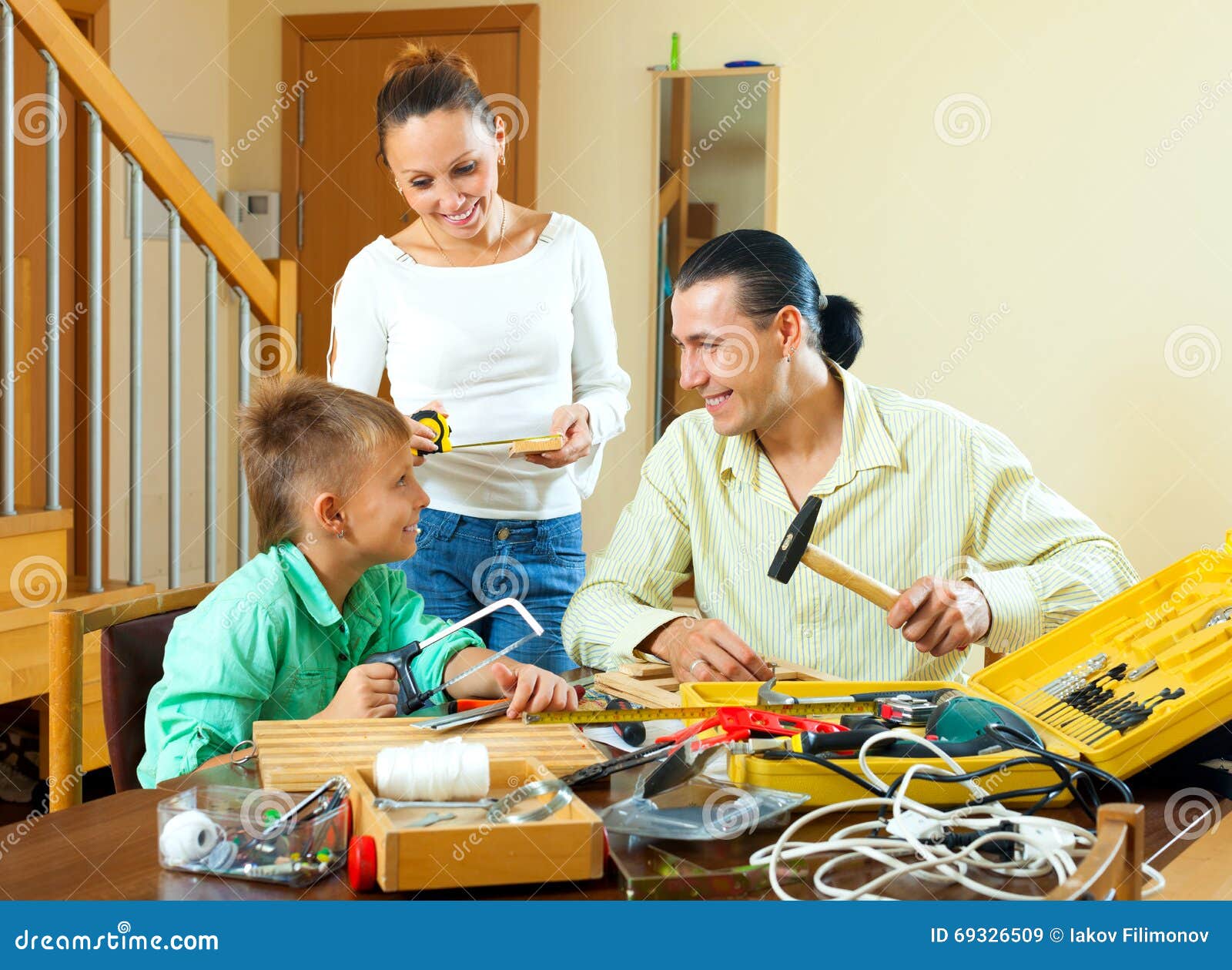 Family of Three with Teenage Boy Making Something with the Working ...