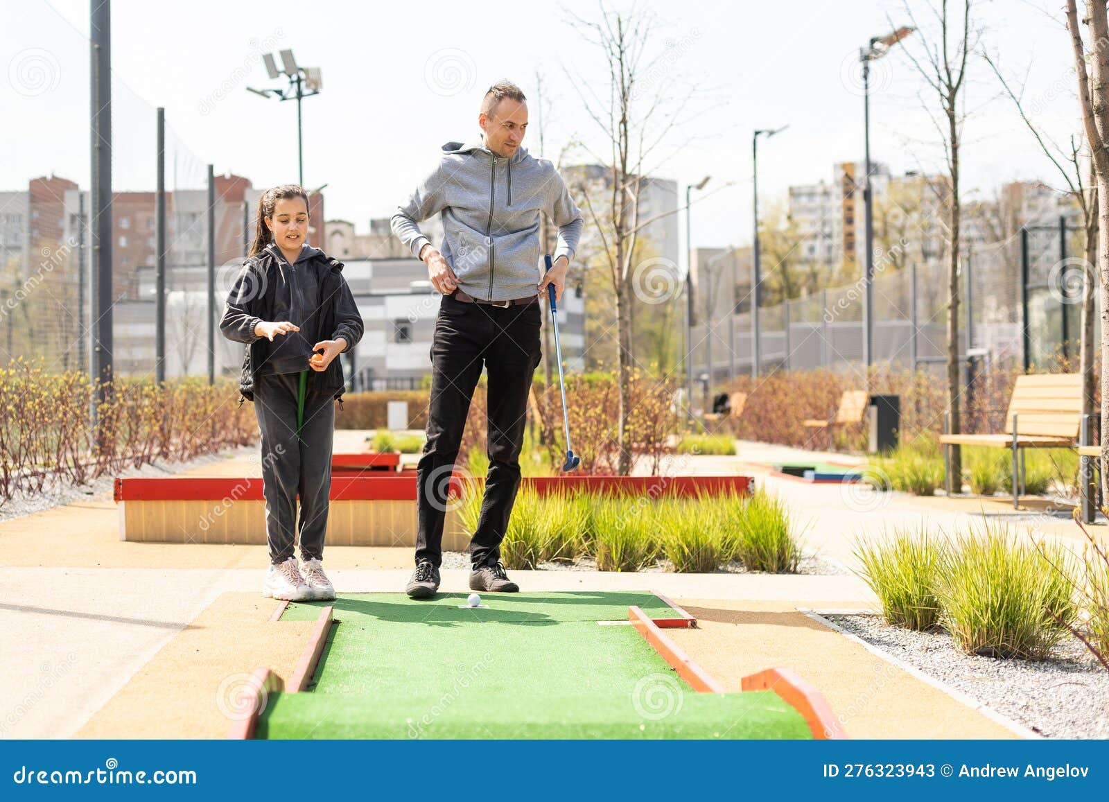 Family Time Playing Mini-Golf in the Summer Stock Image - Image of male ...