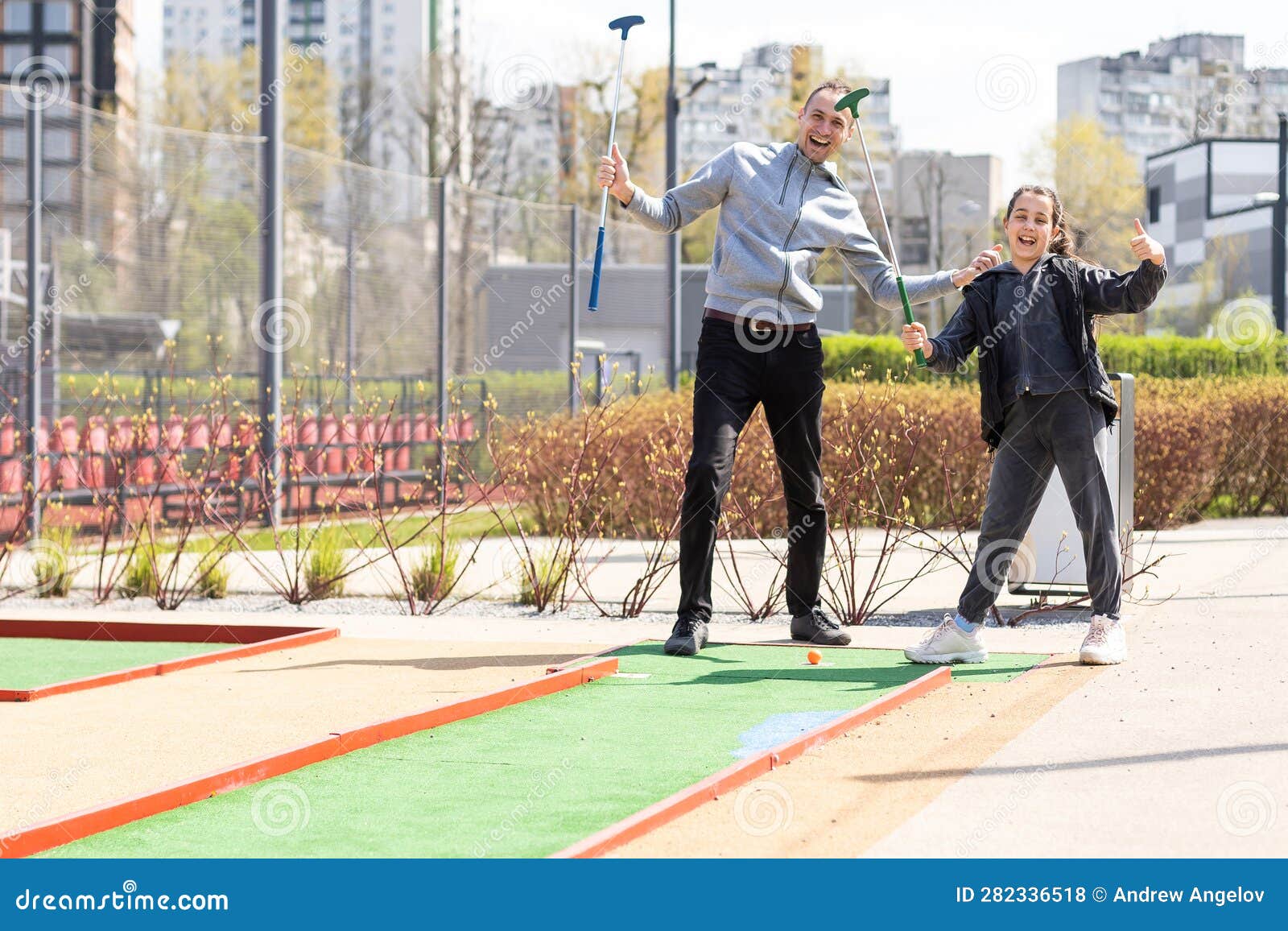 Family Time Playing Mini-Golf in the Summer Stock Photo - Image of putt ...