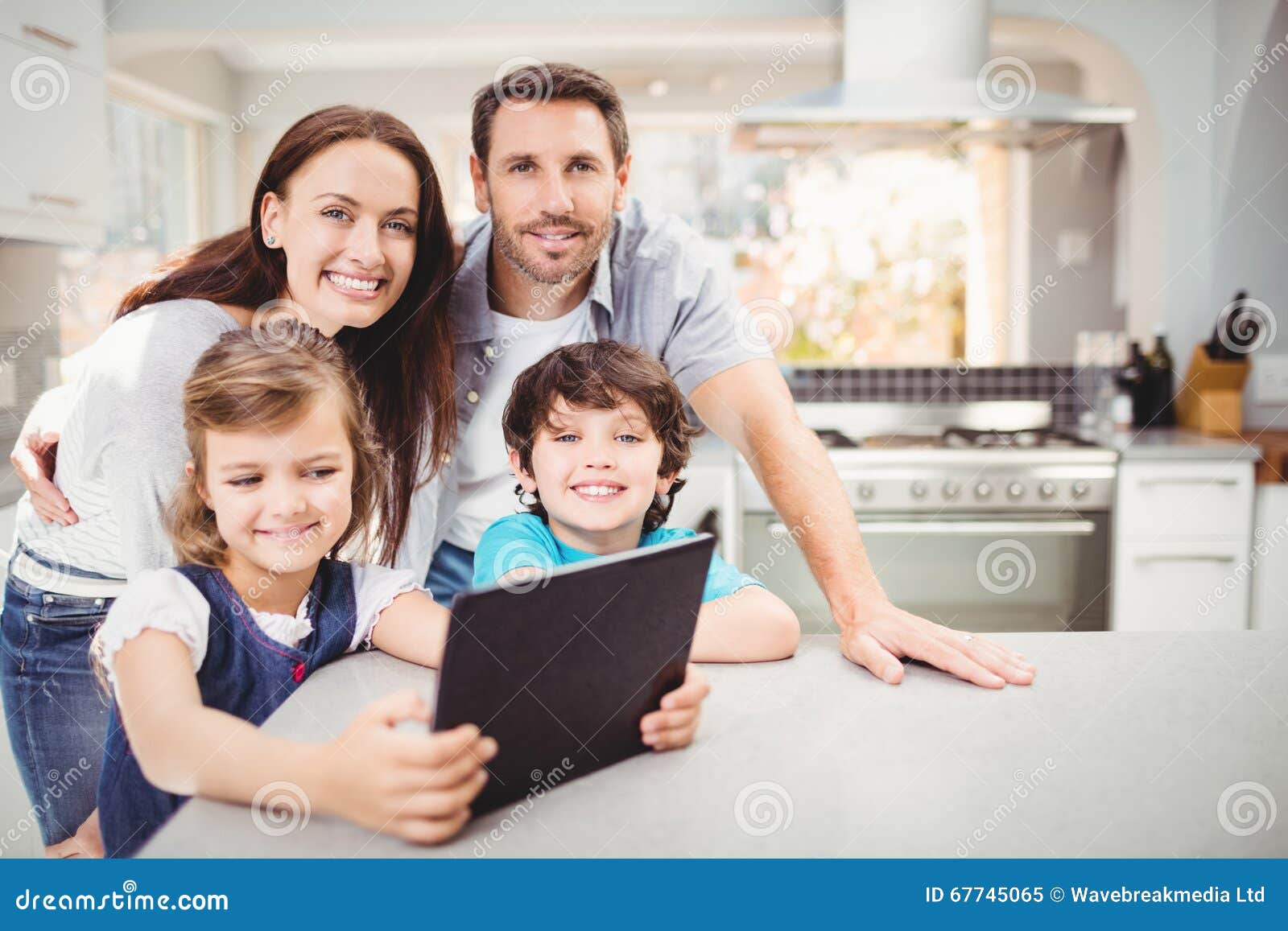 Family Using Digital Tablet while Standing at Table Stock Image - Image ...