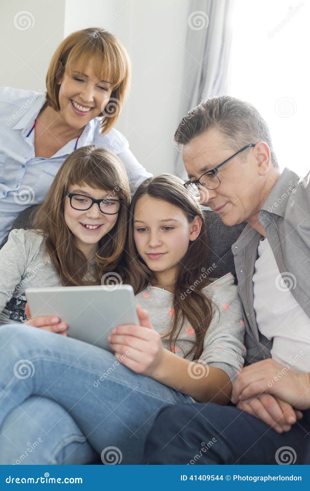 Family Using Digital Tablet Together in Living Room Stock Photo - Image ...