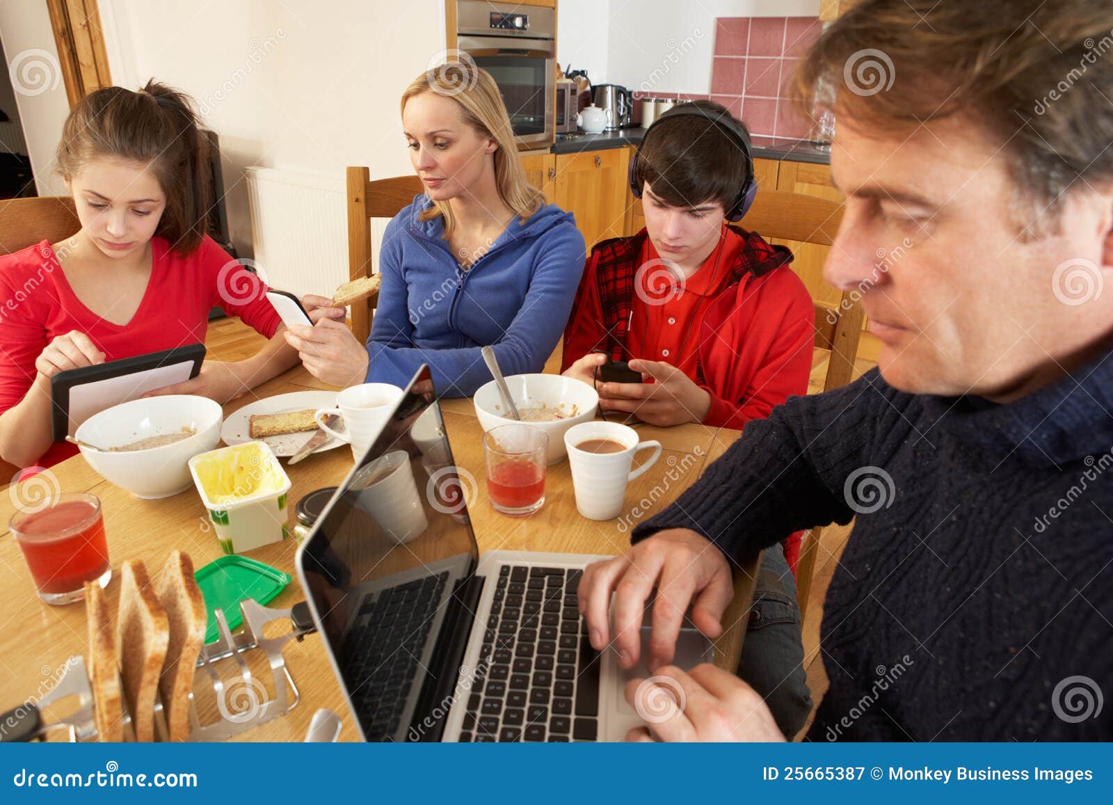 Family Using Gadgets Whilst Eating Breakfast Stock Image - Image of ...