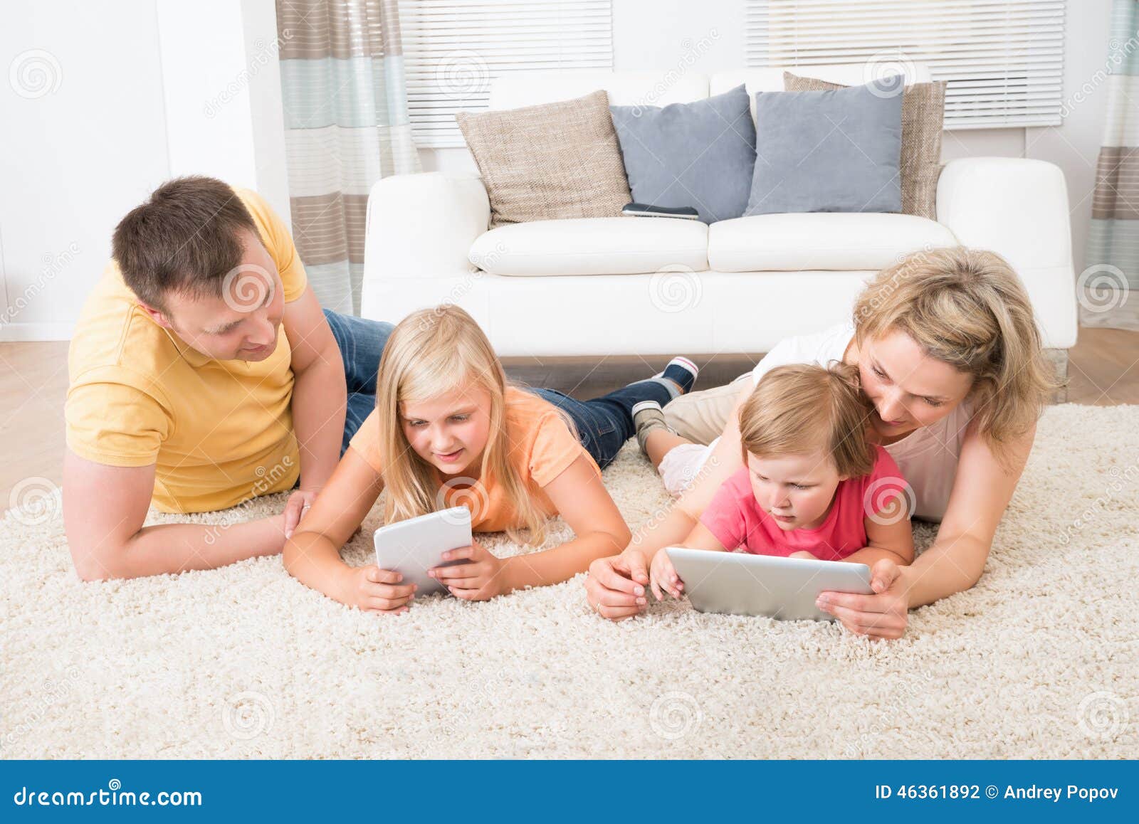 Family Using Tablets Lying on Carpet Stock Photo - Image of ladies ...