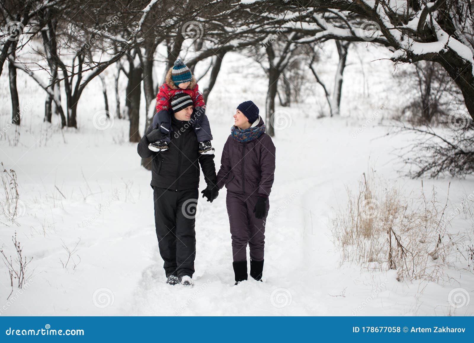 Family Walk through the Snow-covered Forest in Winter. Stock Photo ...