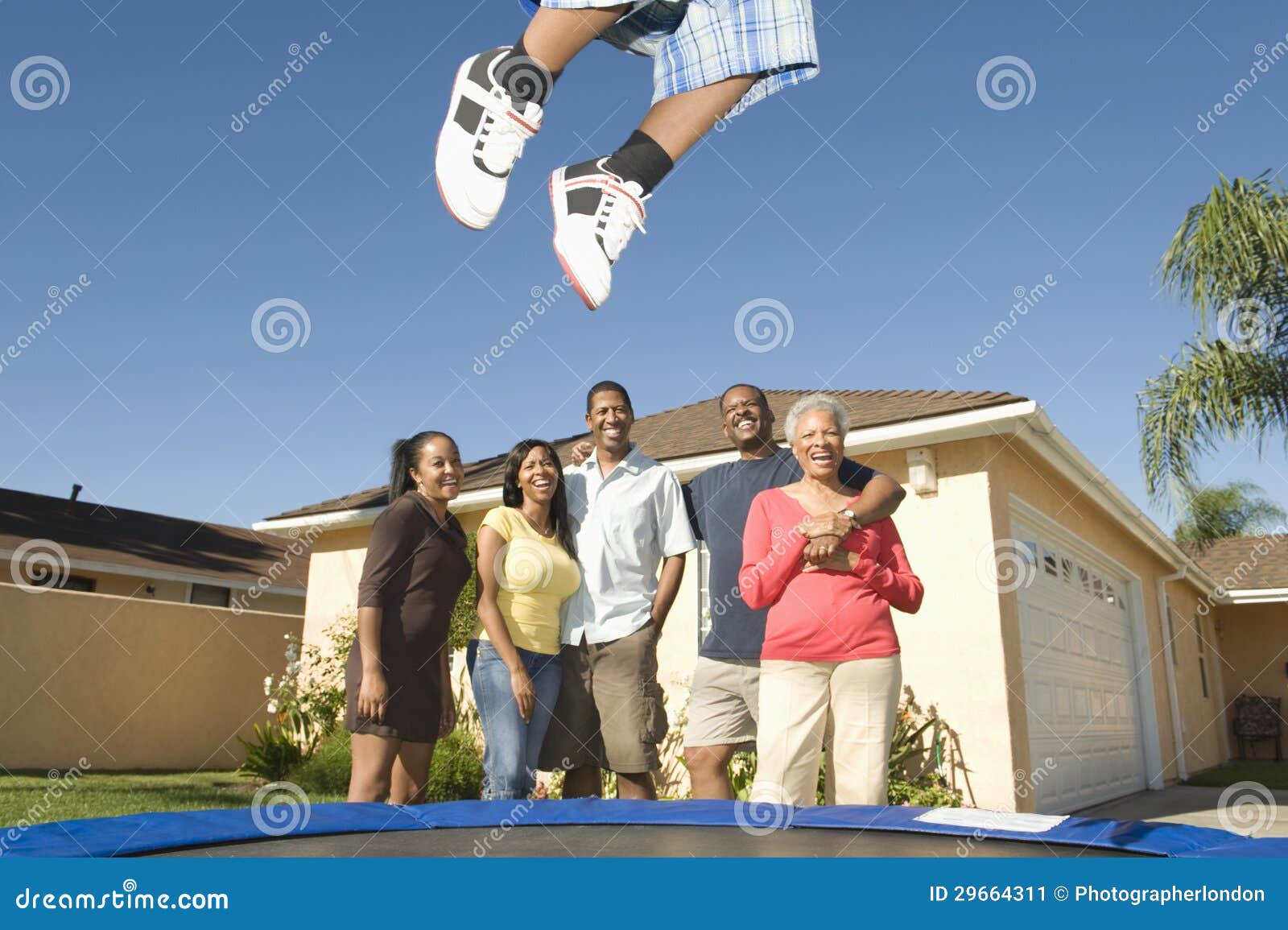 Family Watching Boy Jump on Trampoline Stock Image - Image of african ...