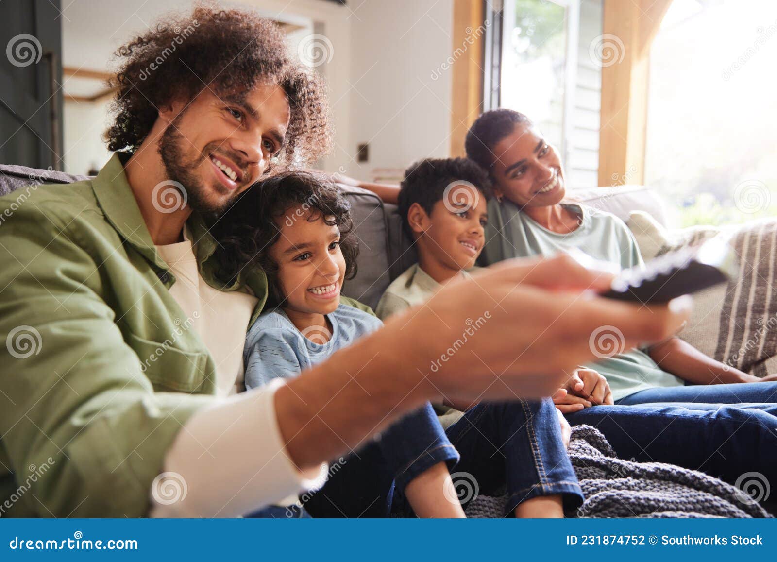 Family Watching TV with Father Using Remote Stock Photo - Image of ...
