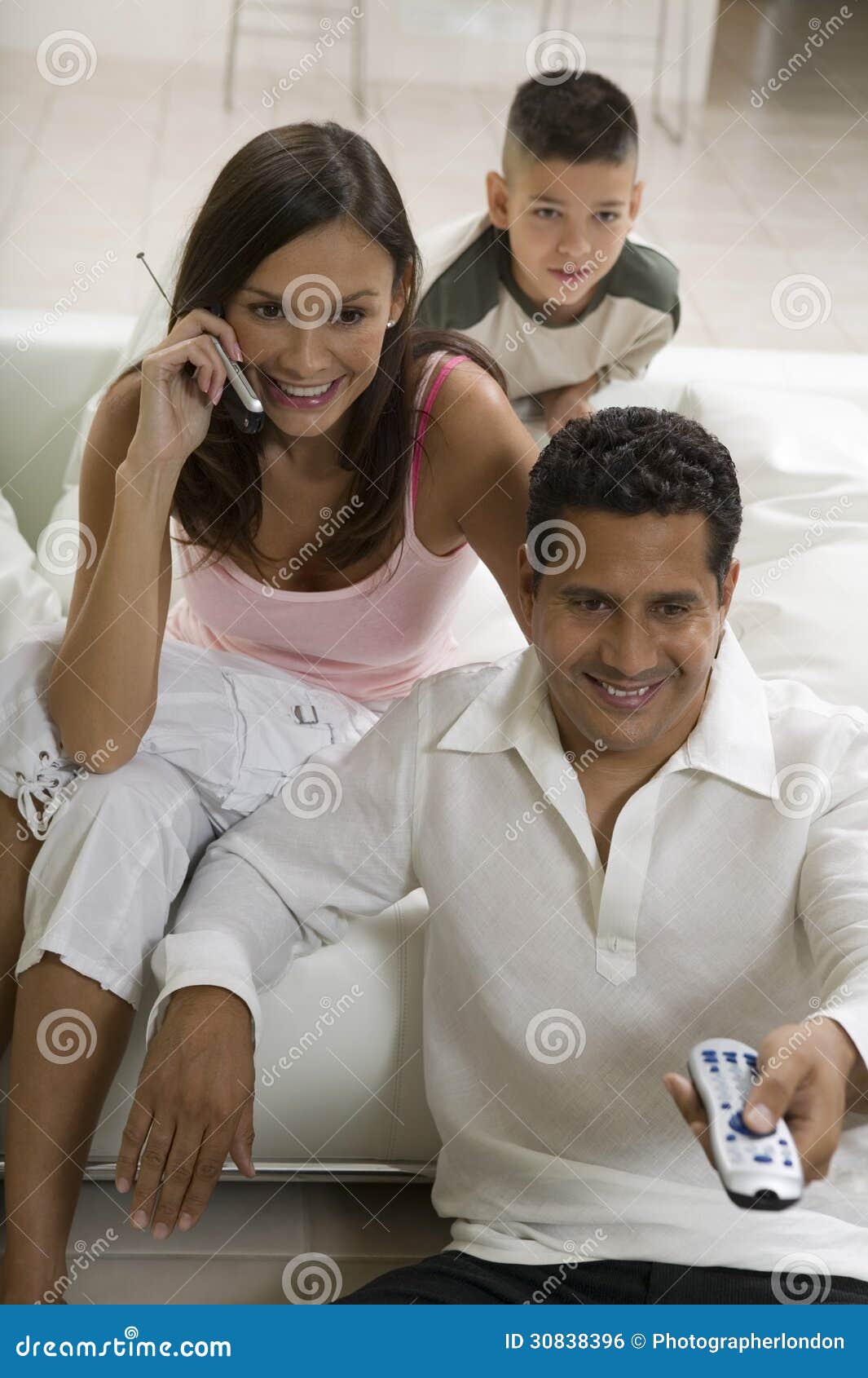 Family Watching TV while Mother on Mobile Phone Stock Photo - Image of ...
