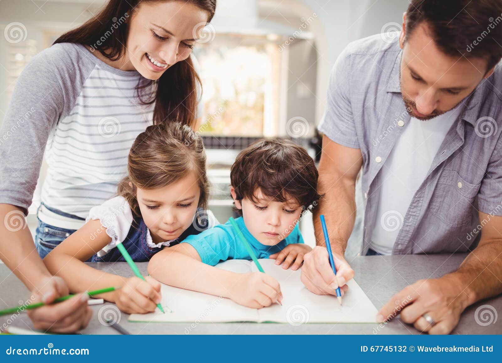 Family Writing in Book while Standing at Table Stock Photo - Image of ...