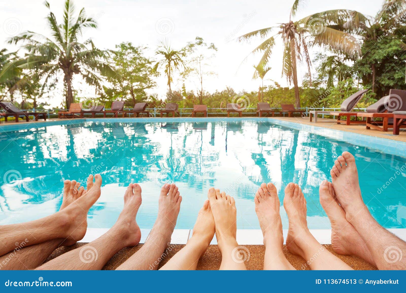 Família Que Relaxa Perto Da Piscina No Hotel Pés Do Grupo De Amigos