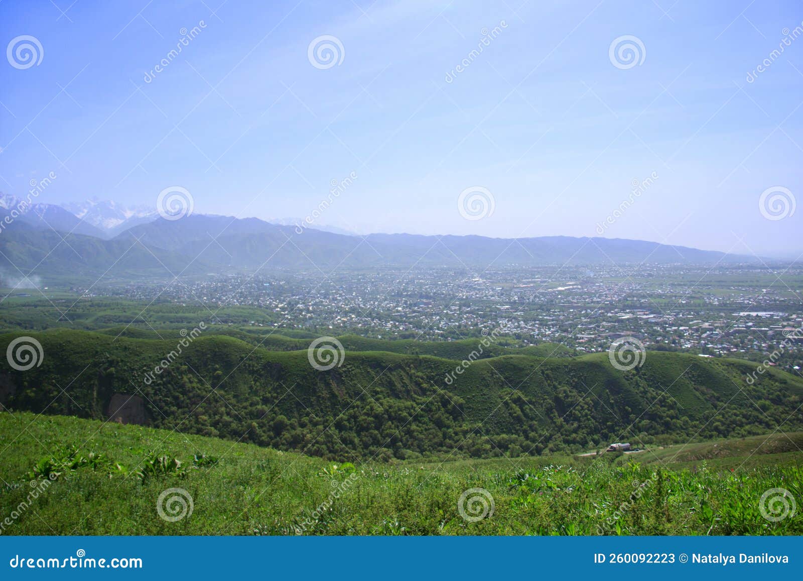 Far View of a High Mountain Range with Green Hills and a Settlement at ...