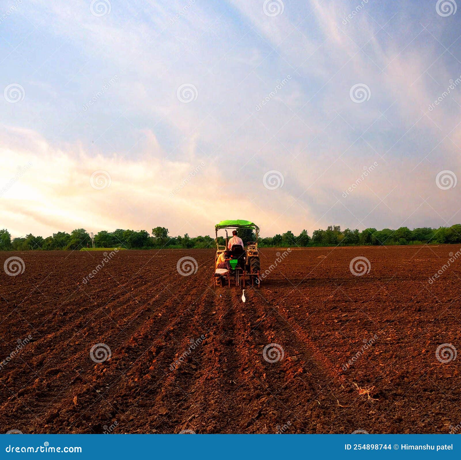 A Farmer Doing Farming with His Tractor in Farm Agriculture Image. Red ...