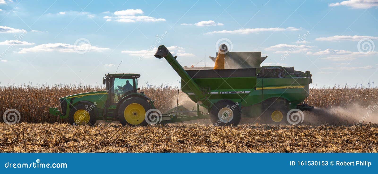 A Farmer Driving His John Deere Tractor Pulling a Grain Hopper ...