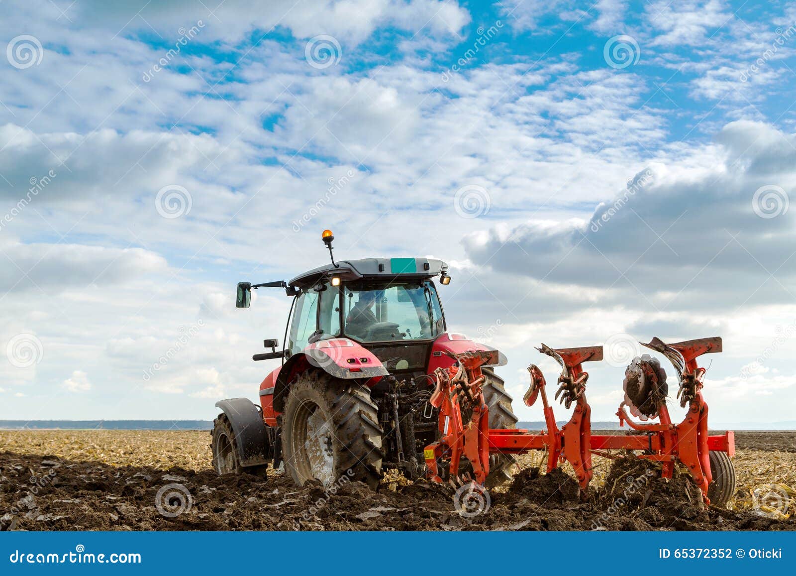 Farmer Plowing Stubble Field with Red Tractor. Stock Photo - Image of ...