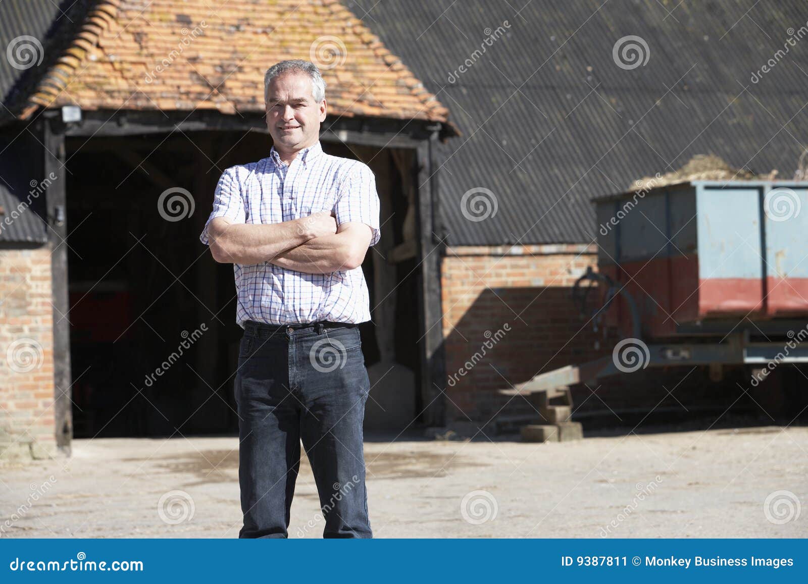Farmer Standing in Front of Farm Buildings Stock Image - Image of ...