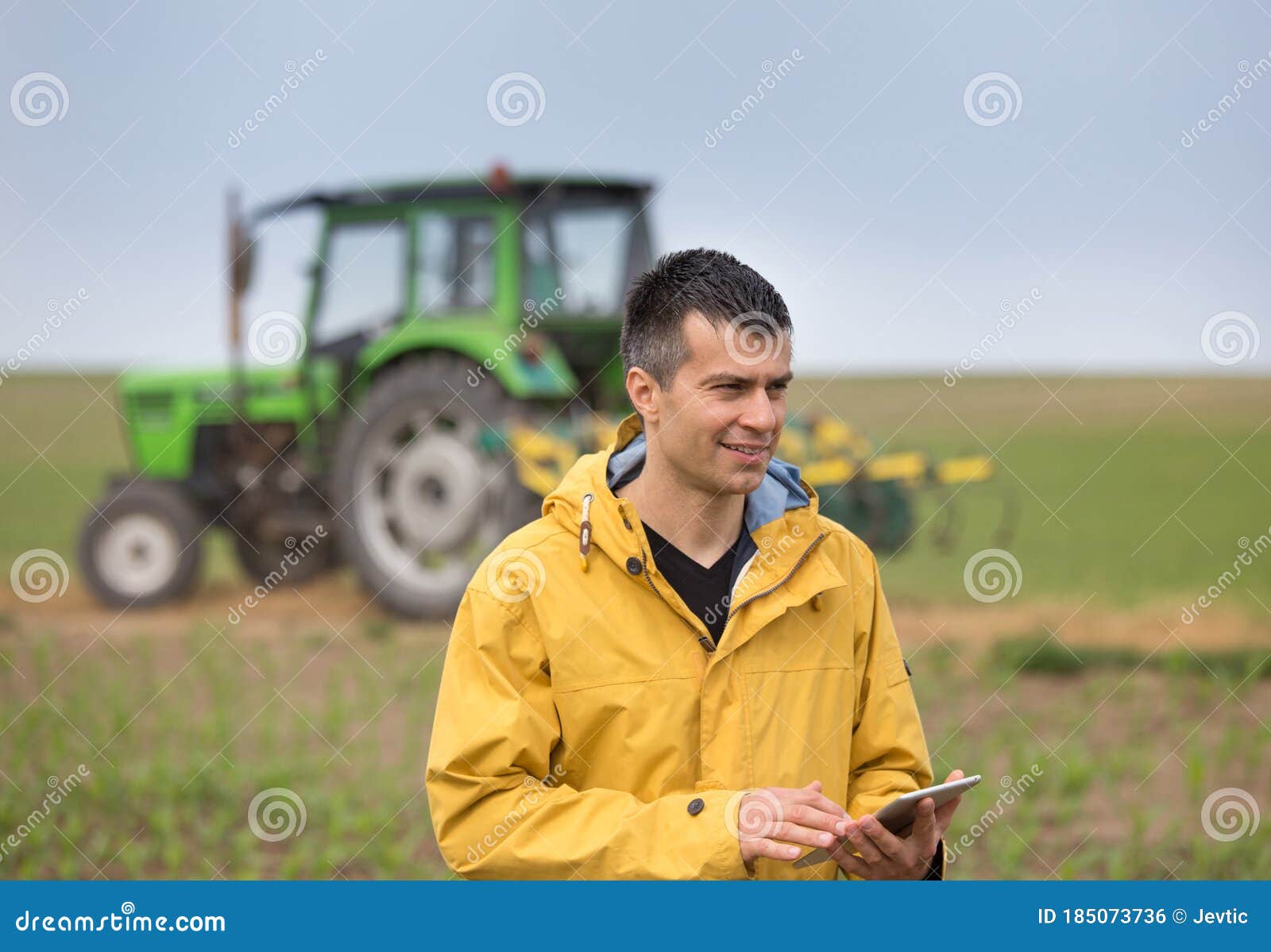 Farmer with Tablet in Front of Tractor in Field Stock Photo - Image of ...