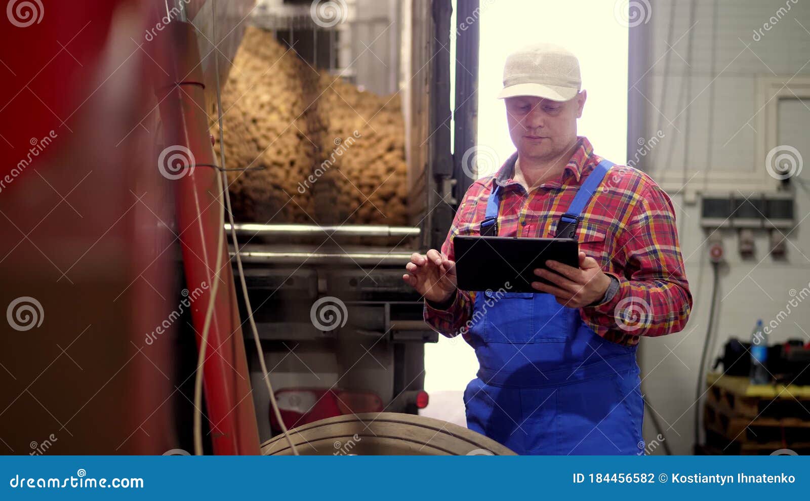 Farmer with Tablet in Potato Storage Warehouse. Background of Loading ...