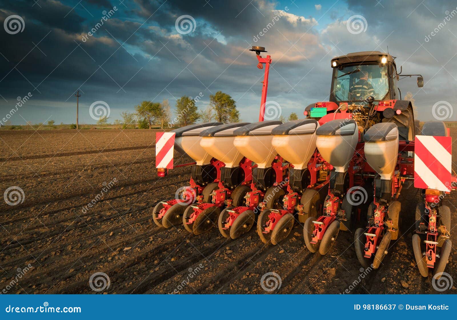 Farmer with Tractor Seeding - Sowing Crops at Agricultural Field Stock ...
