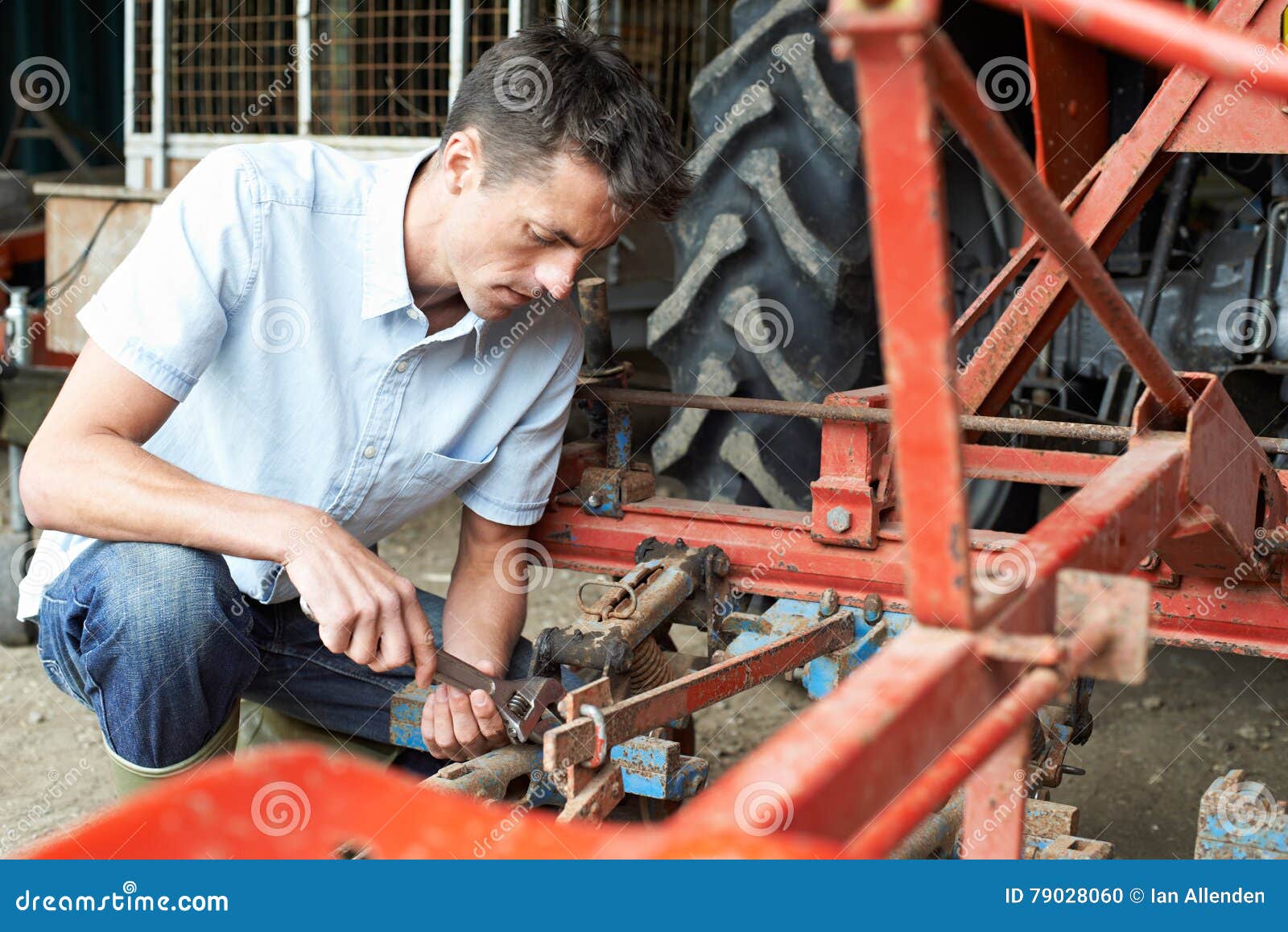 Farmer Working on Agricultural Equipment in Barn Stock Photo - Image of ...