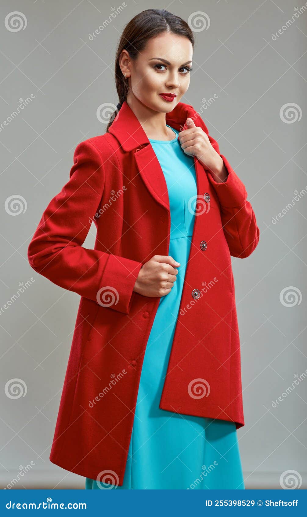 Fashion Model Dressed In Red Coat And Light Blue Dress Posing I Stock