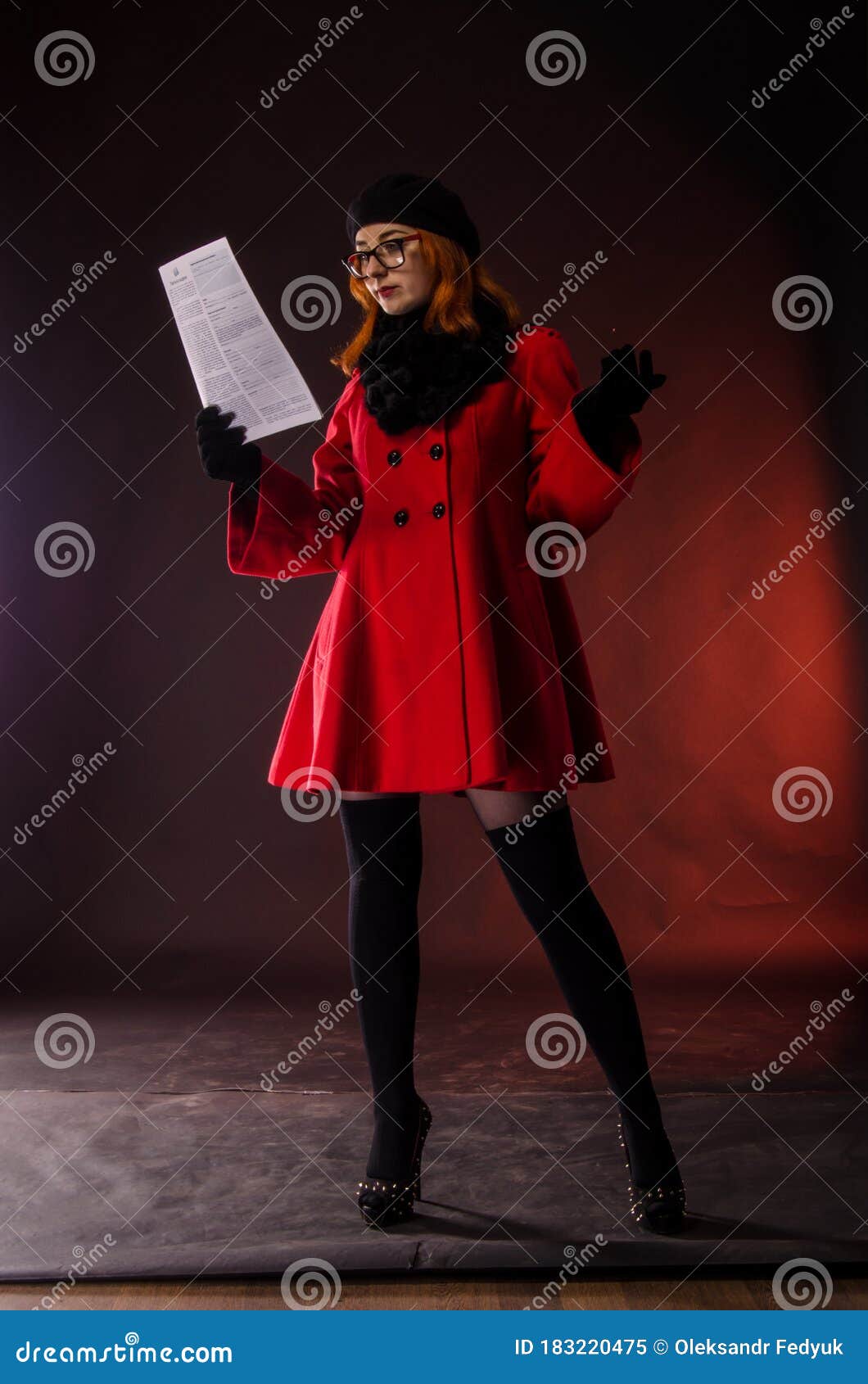 Fashion Model in Red Coat Looking Down with Smile on Her Face Stock ...