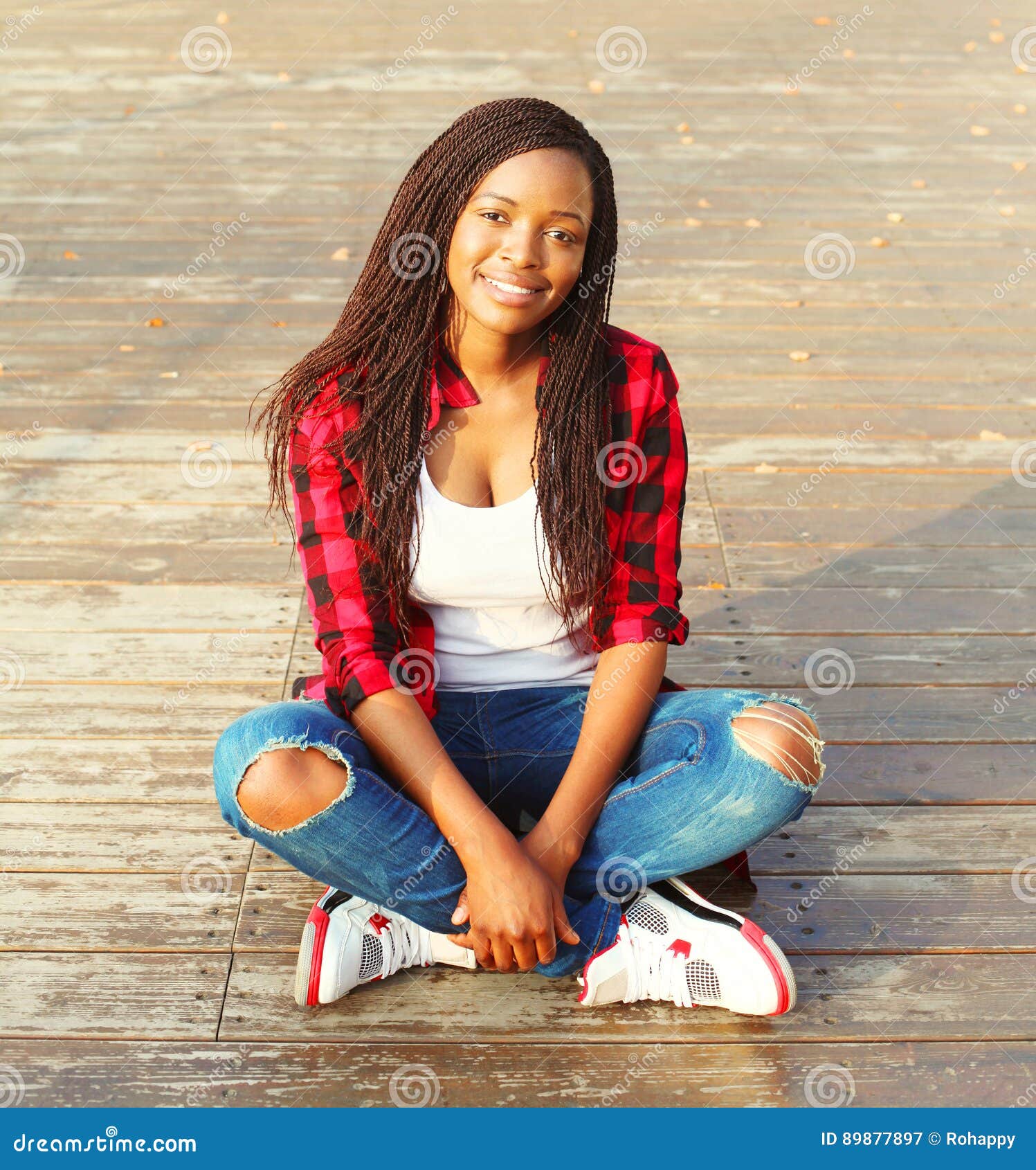 Fashion Pretty Young African Woman Sitting In The City Park Wearing A