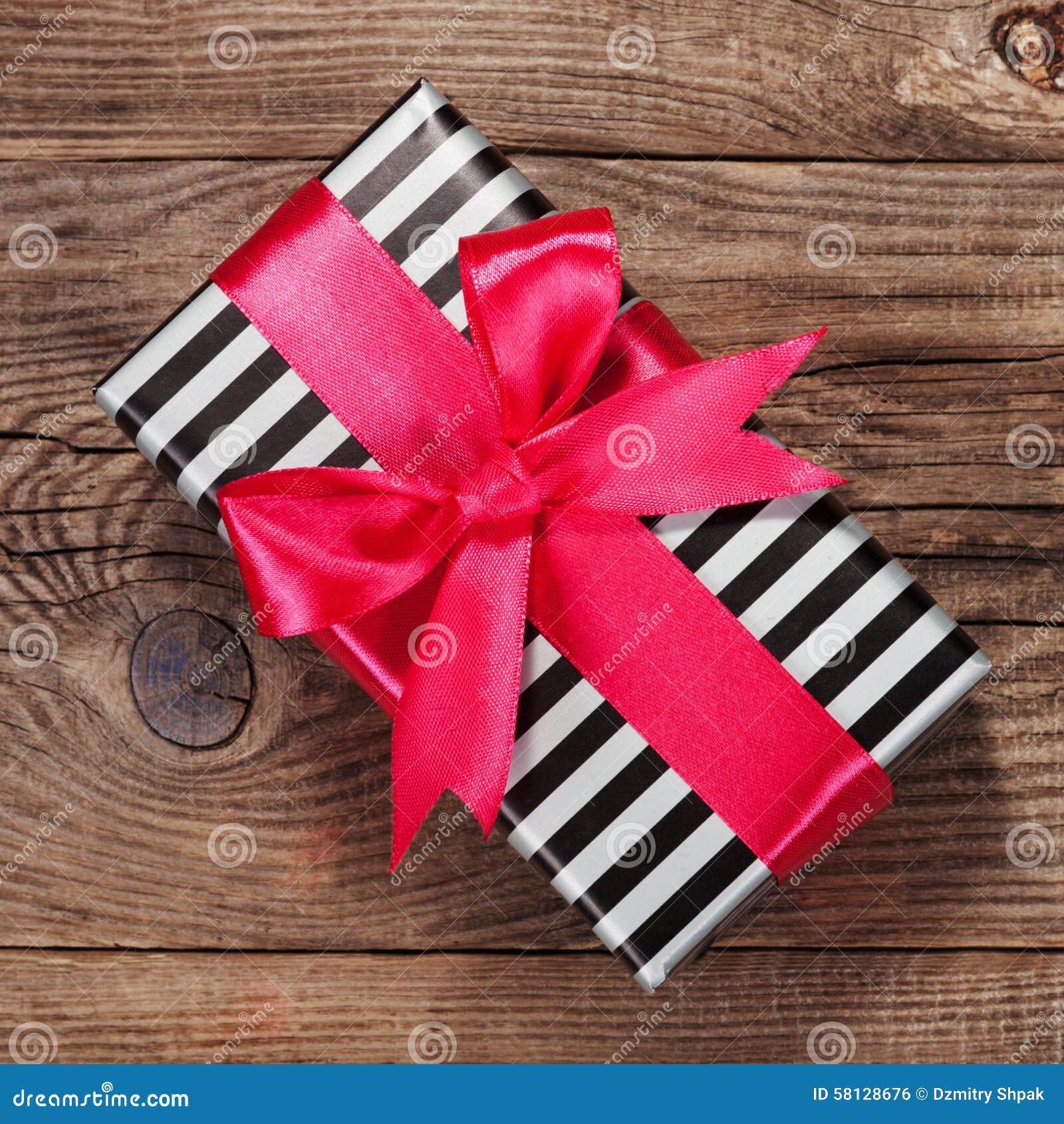 Fashionable Striped Gift Box with a Pink Bow on Board. Stock Photo ...