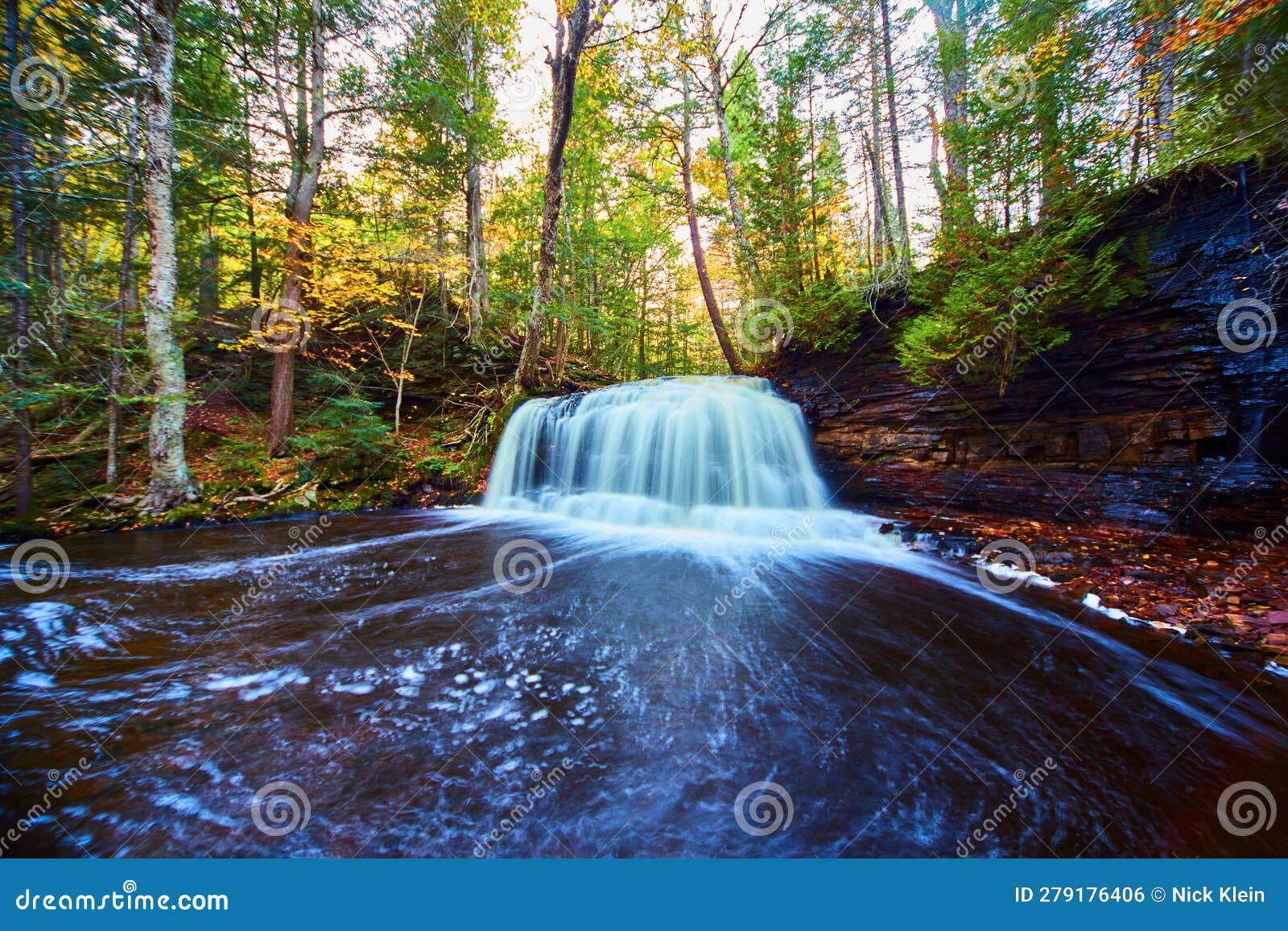 Fast Flowing Water from Large Waterfall with Black and Brown Cliff and ...