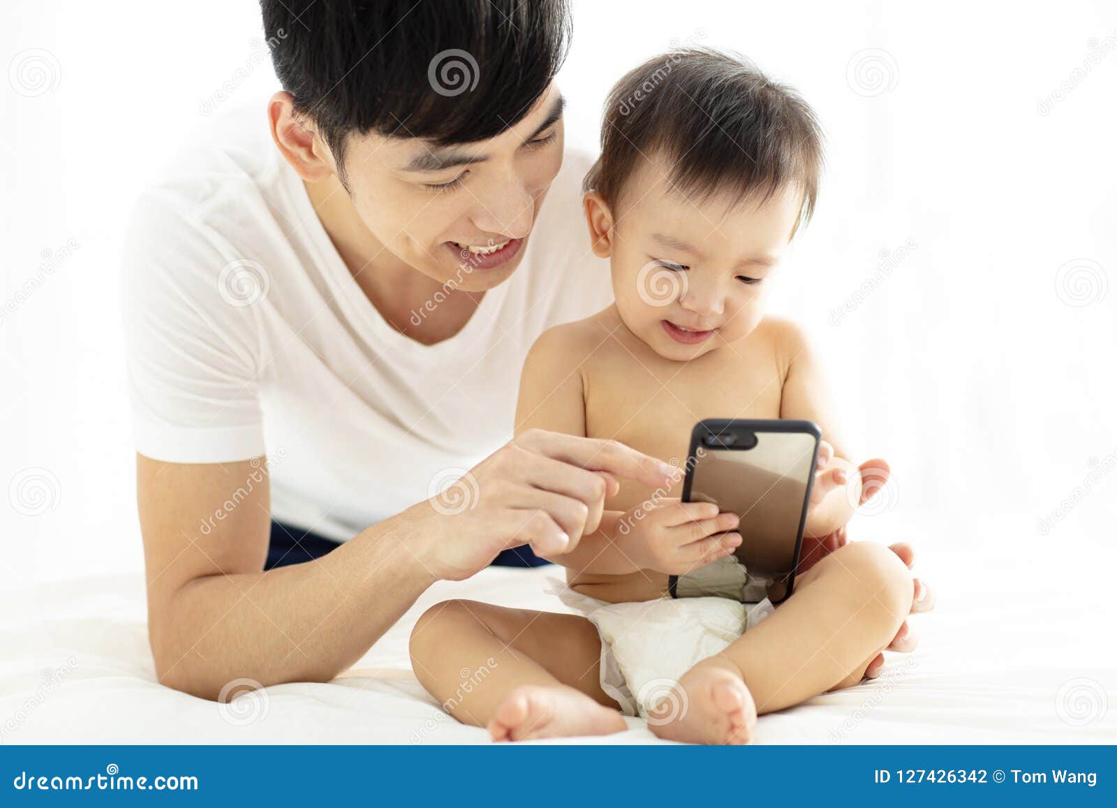 Father and Baby Boy Watching the Mobile Phone Stock Photo - Image of ...