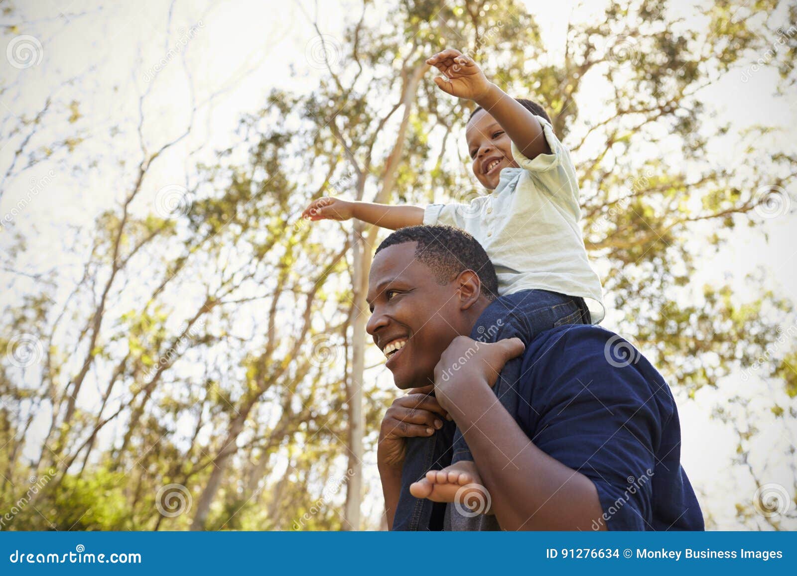 Father Carrying Son on Shoulders As they Walk in Park Stock Photo ...