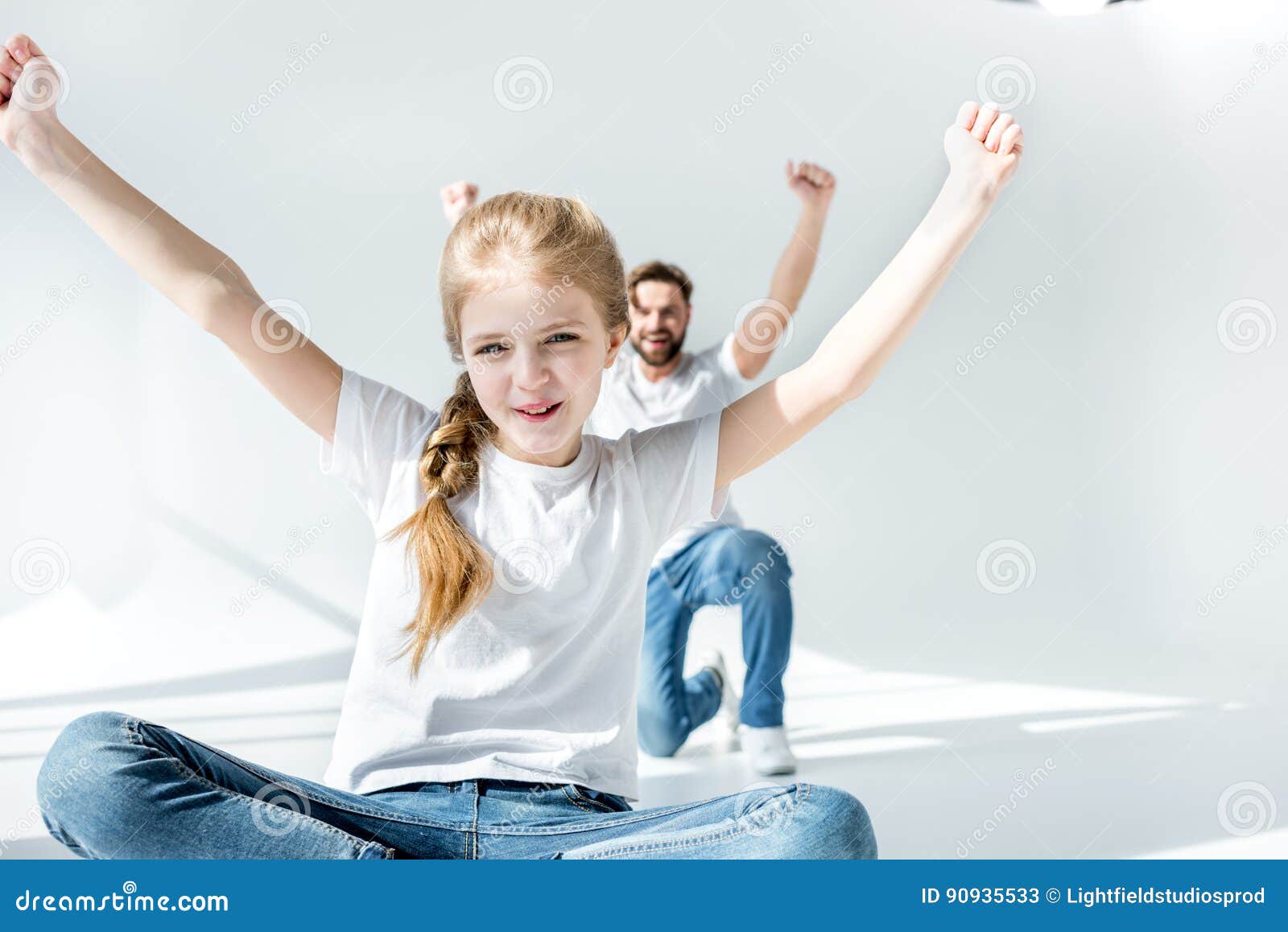 Father and Daughter Cheering with Raised Hands on Grey Stock Image ...